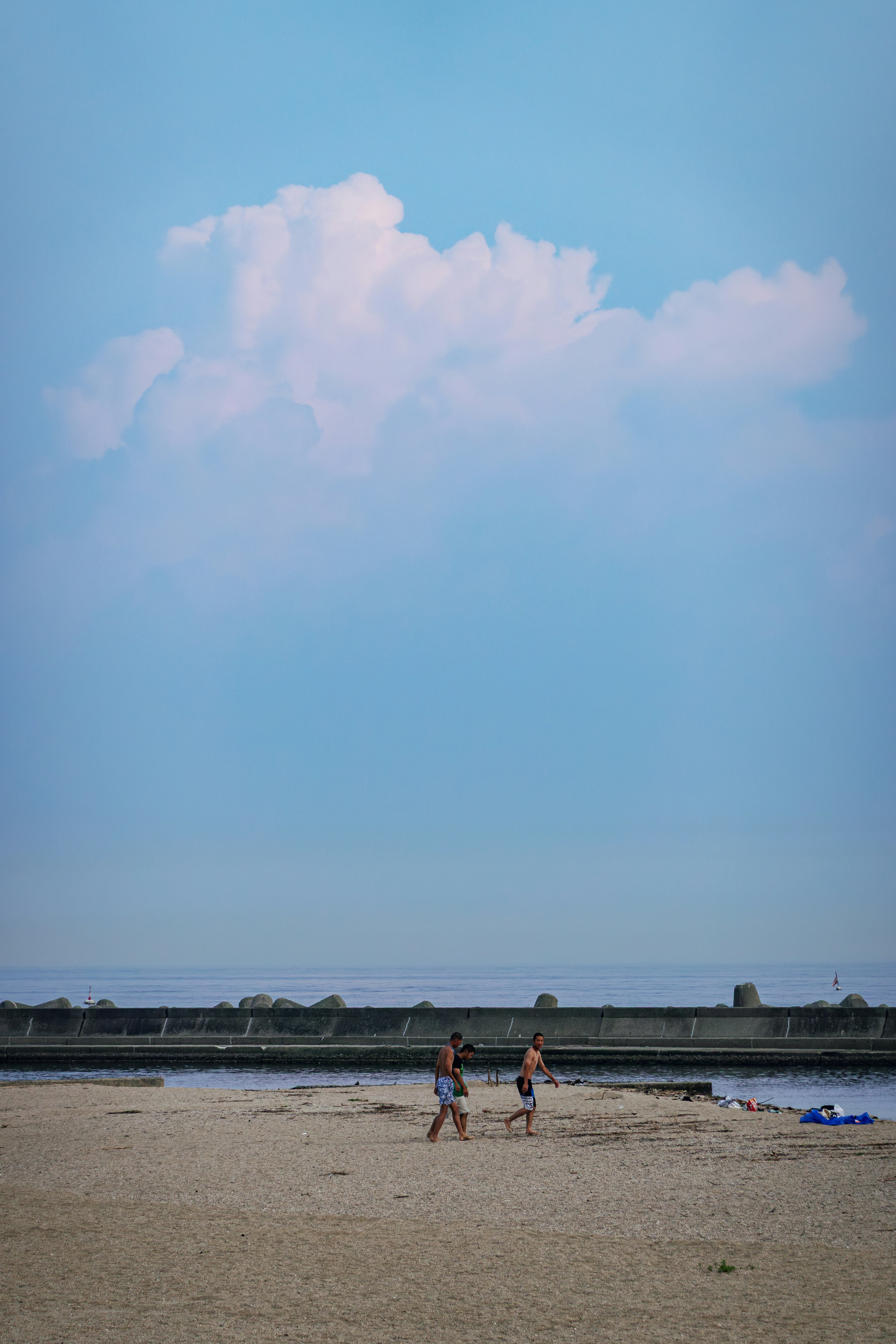 Two Figures on a Quiet Beach Under a Vast Cloudscape