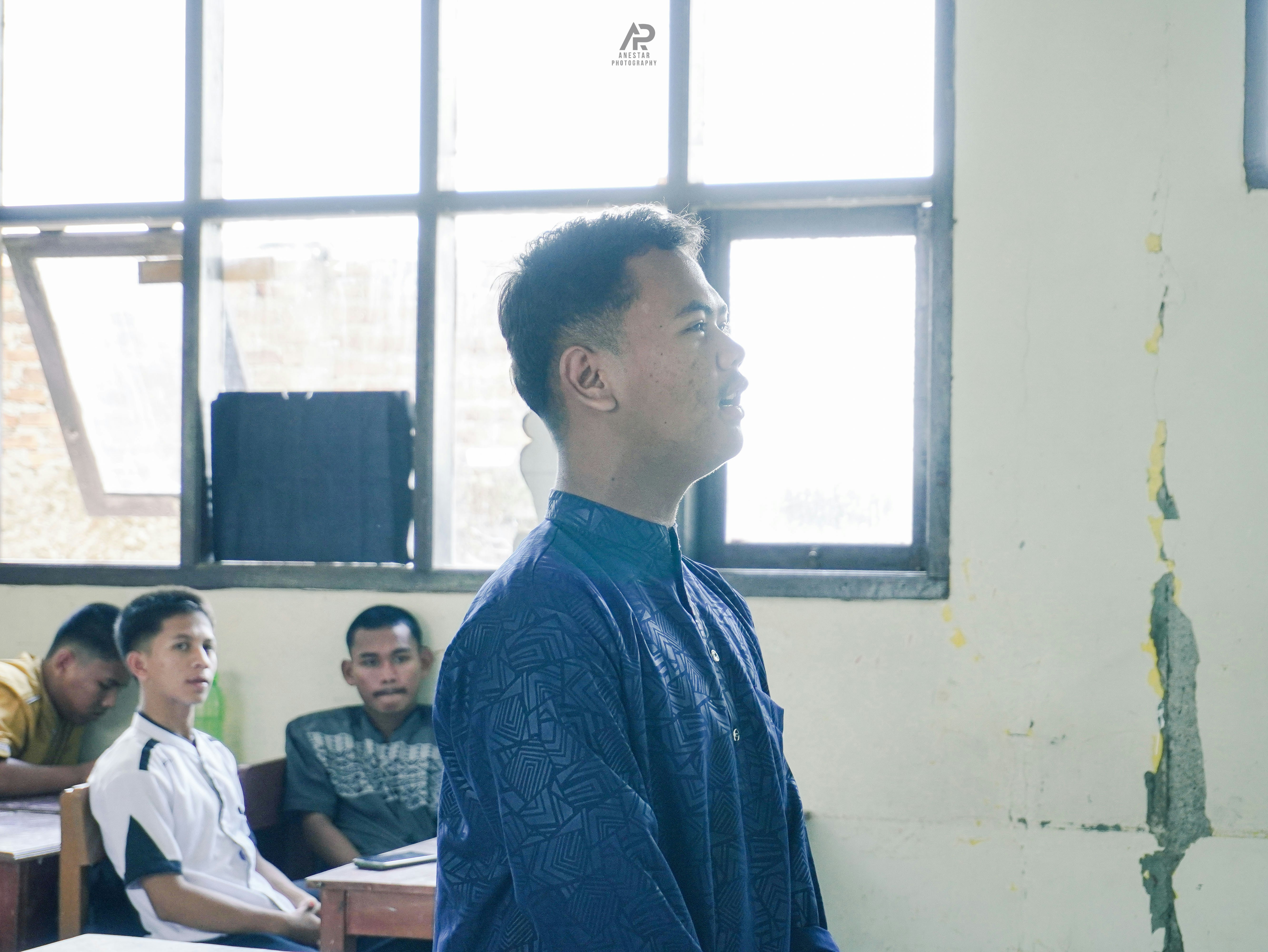 Young man in blue shirt facing window with others. photo – Free Image ...