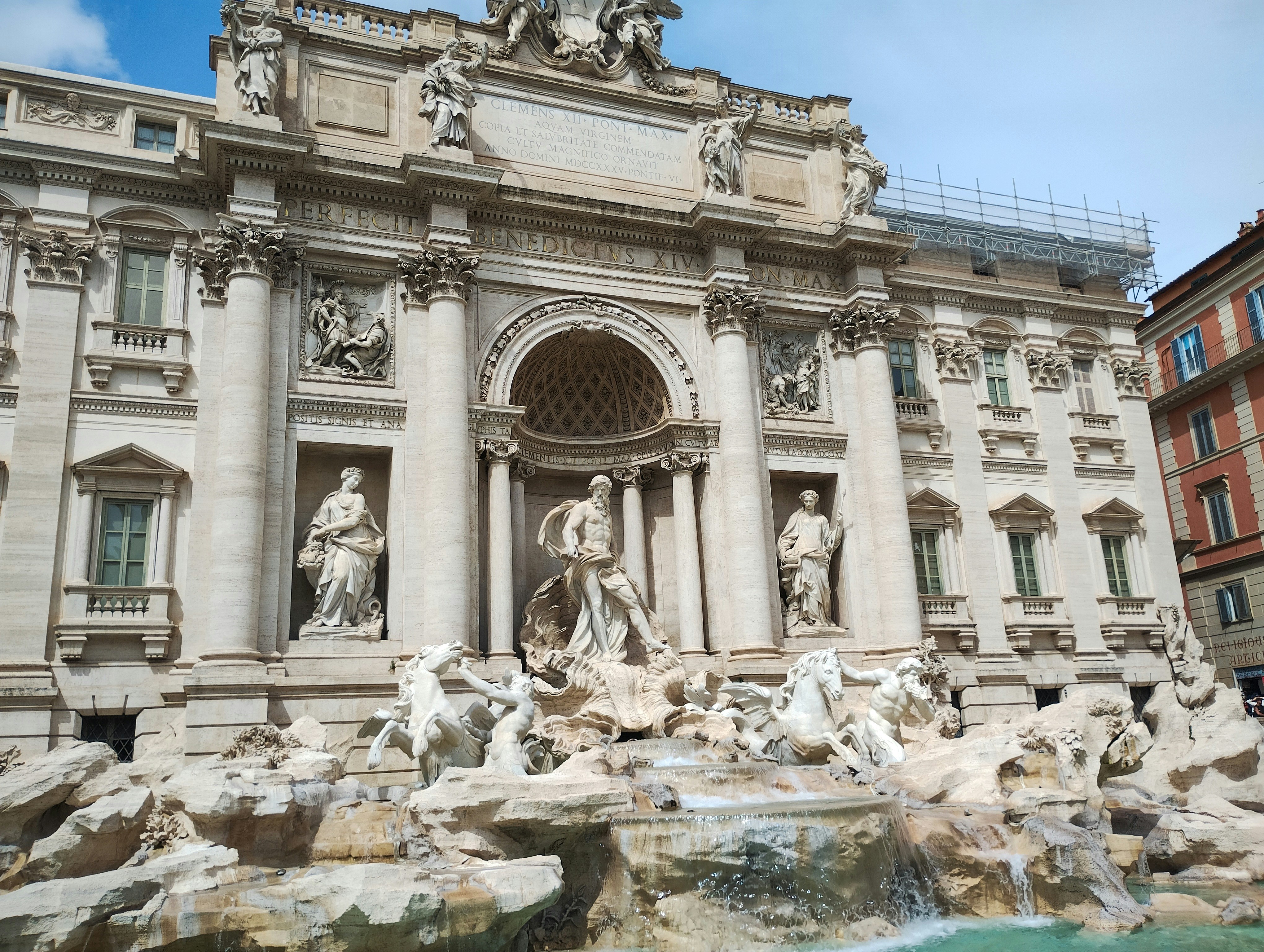 A monument in Rome, Italy, with statues in the middle of it. | The trevi fountain in rome with its sculptures and water.