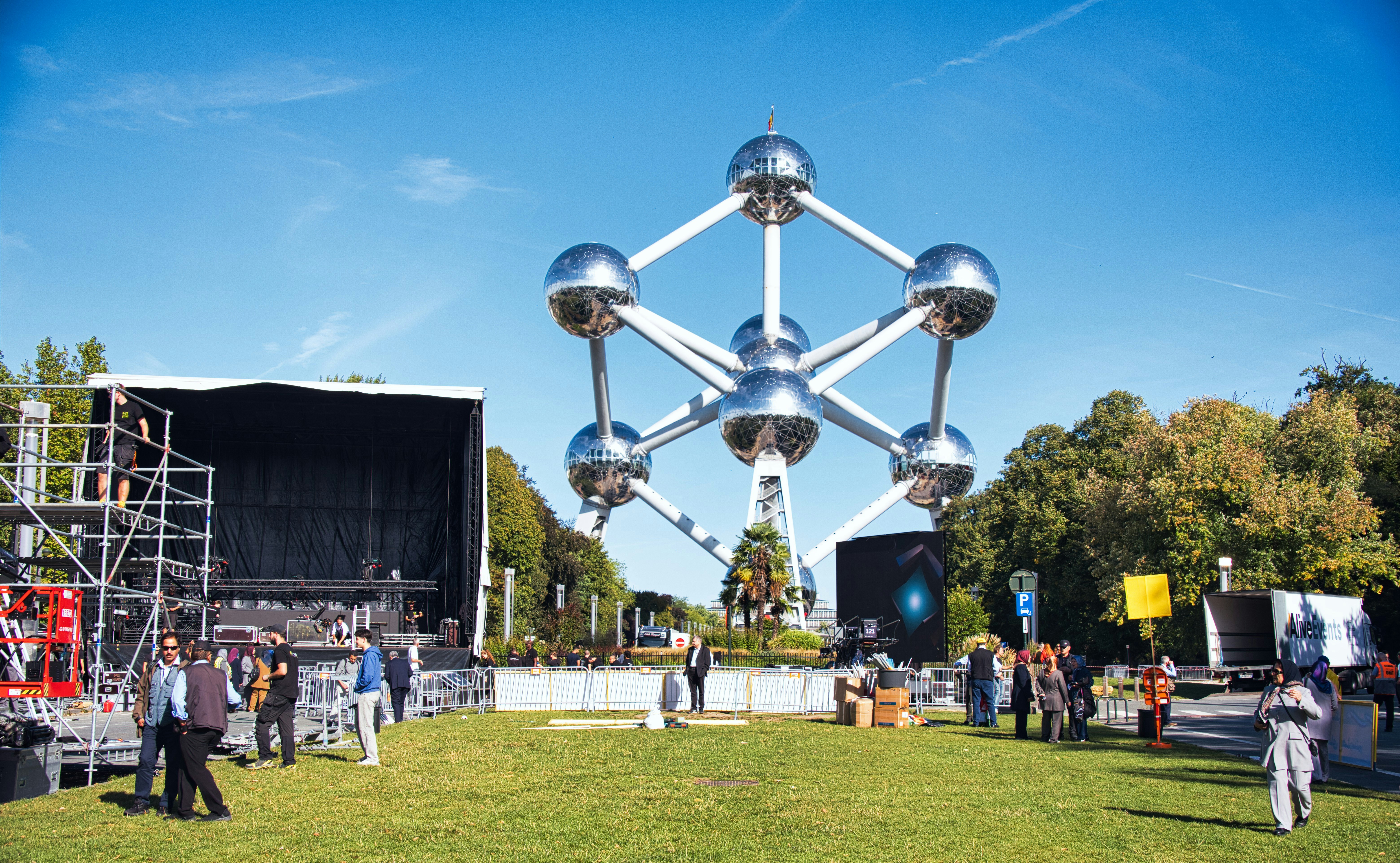 A concert stage is being built at the Atomium, Brussels. | The atomium structure with people gathered outdoors