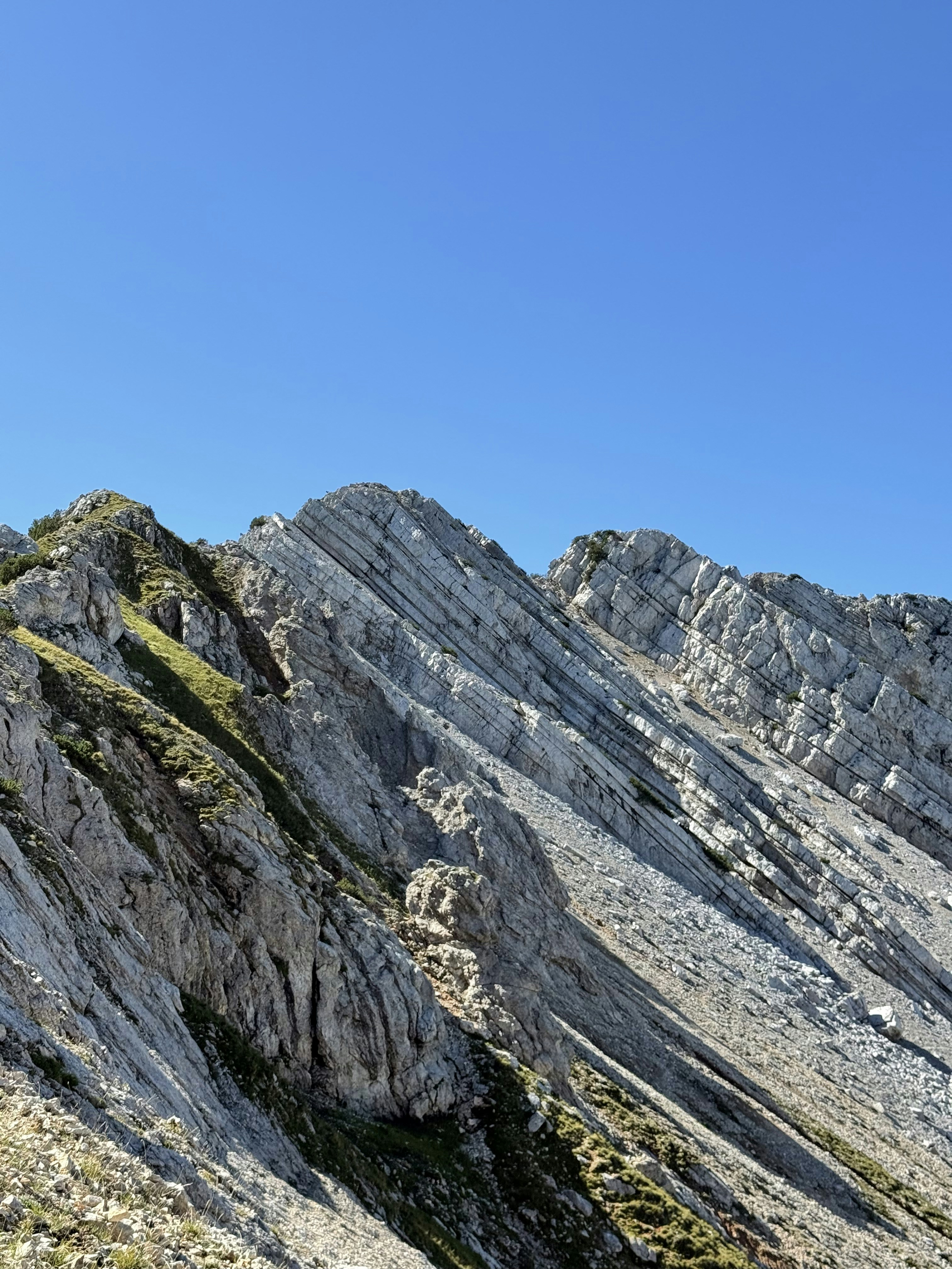 Cresta de las montañas rocosas bajo un cielo azul claro foto – Imagen ...
