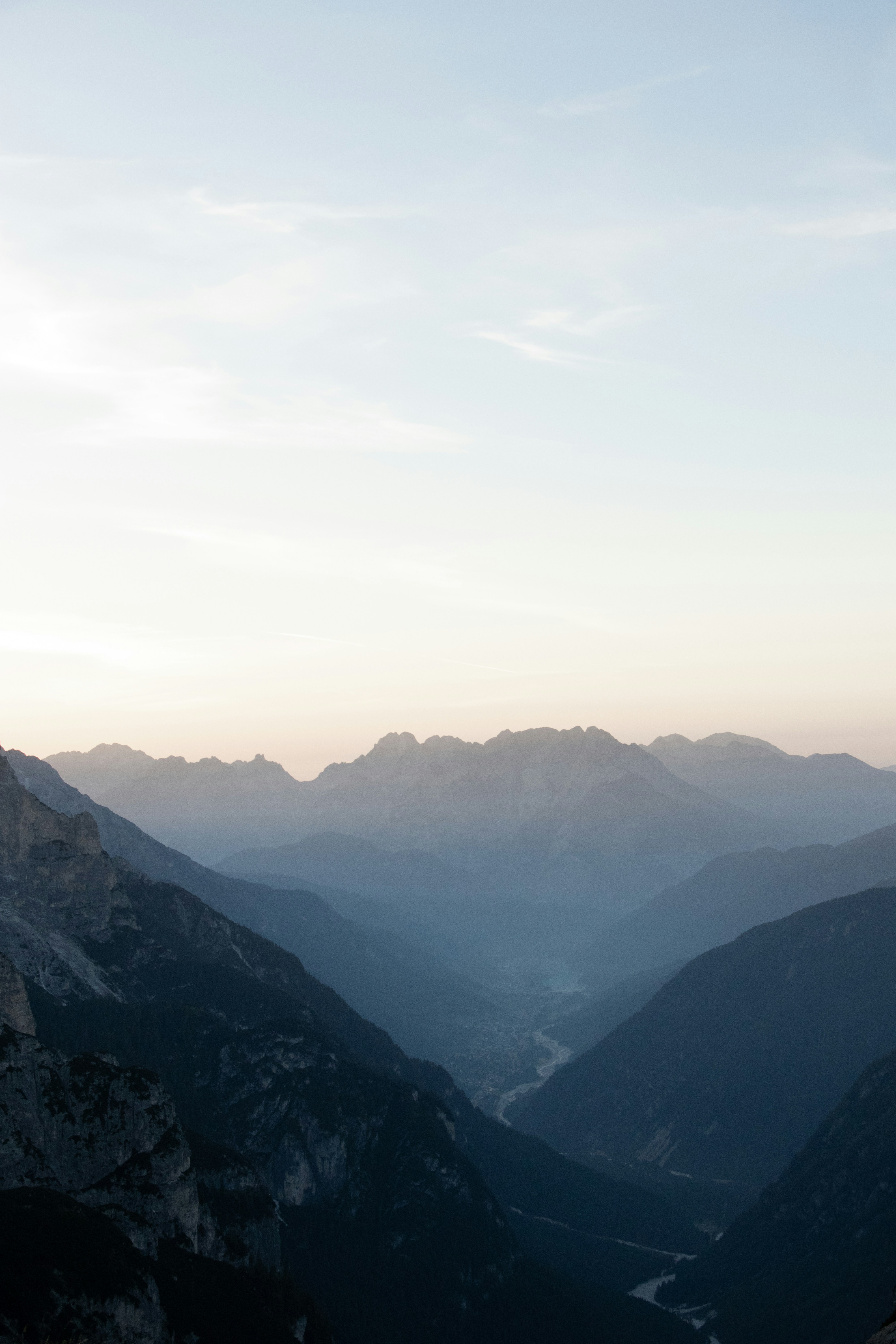 Layered mountain ranges fade into the hazy sky.