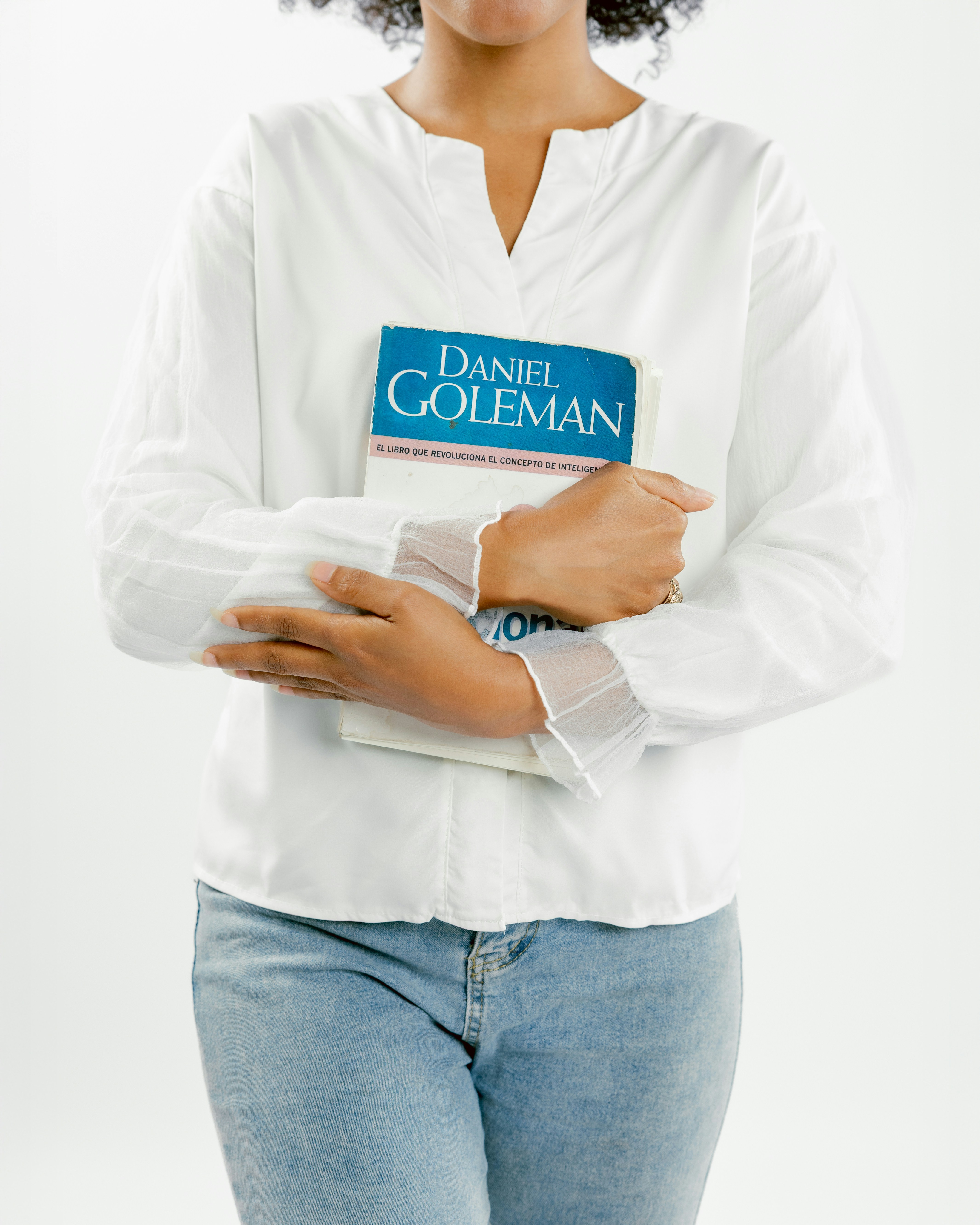 Daniel Goleman | Woman in white shirt holding a book