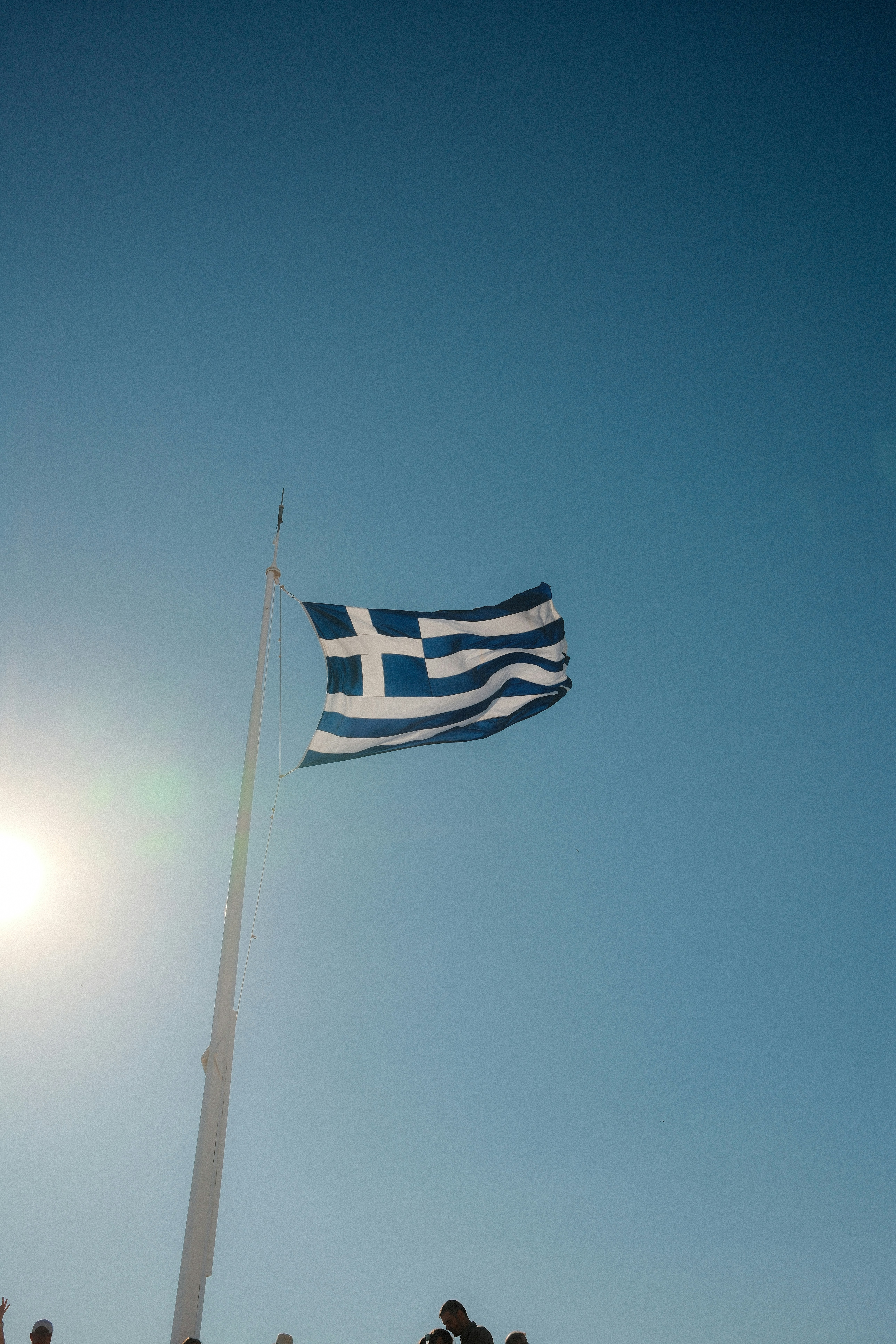 Waves of Heritage: The Greek Flag Against the Sky
