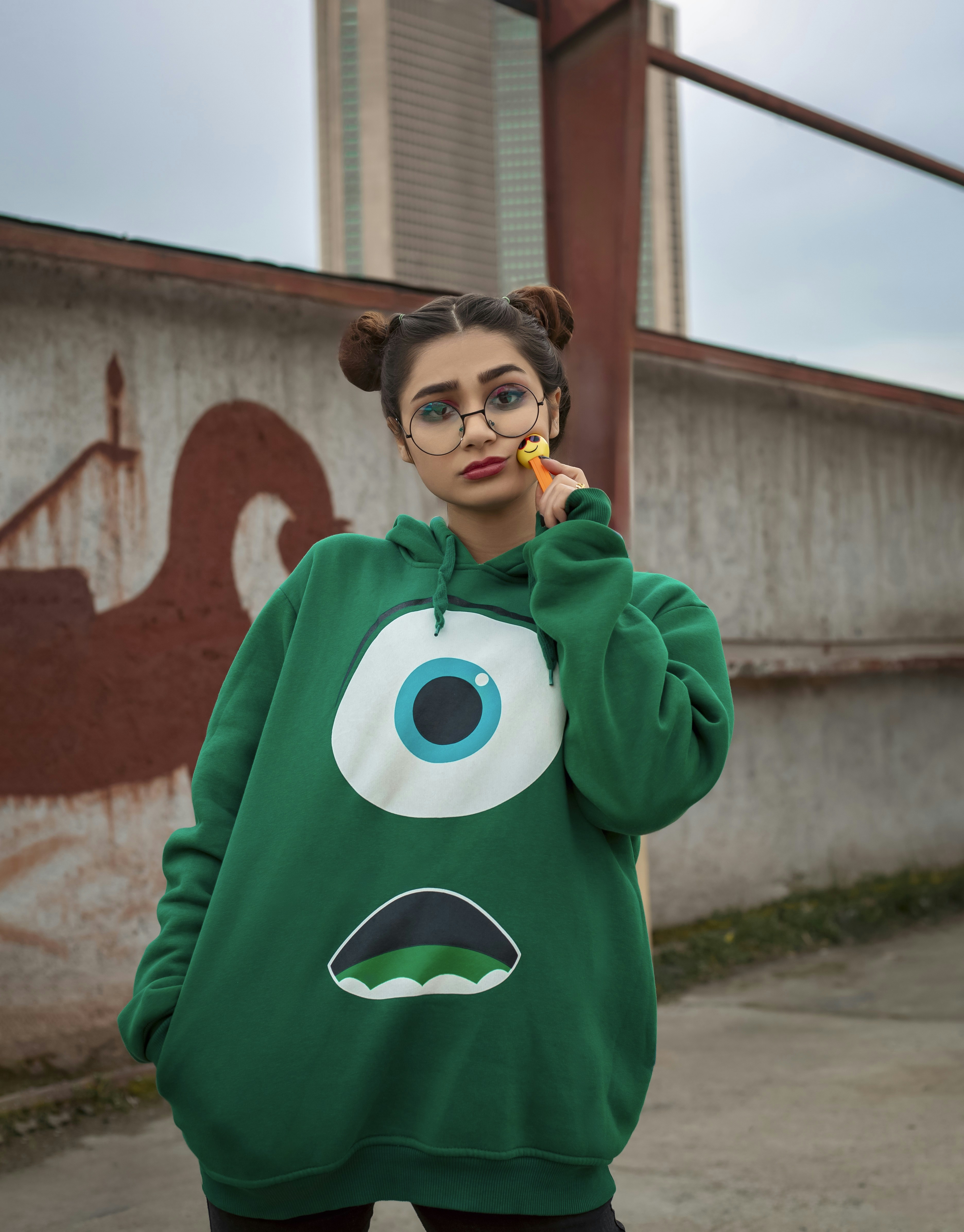 Rooftop Gaze in a Green Cartoon Hoodie: A Bold Street Portrait
