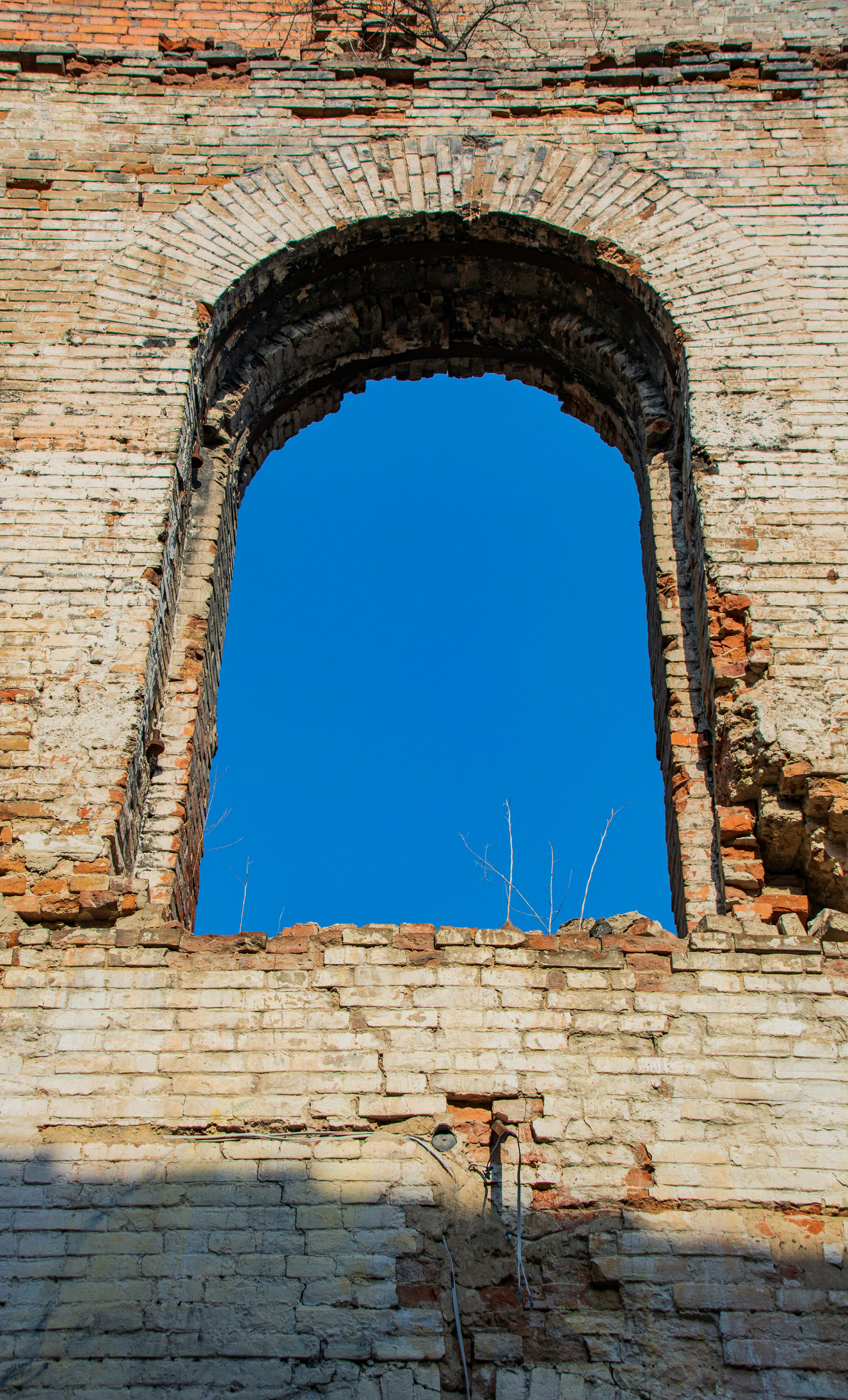 Ruined brick wall with an arched window opening