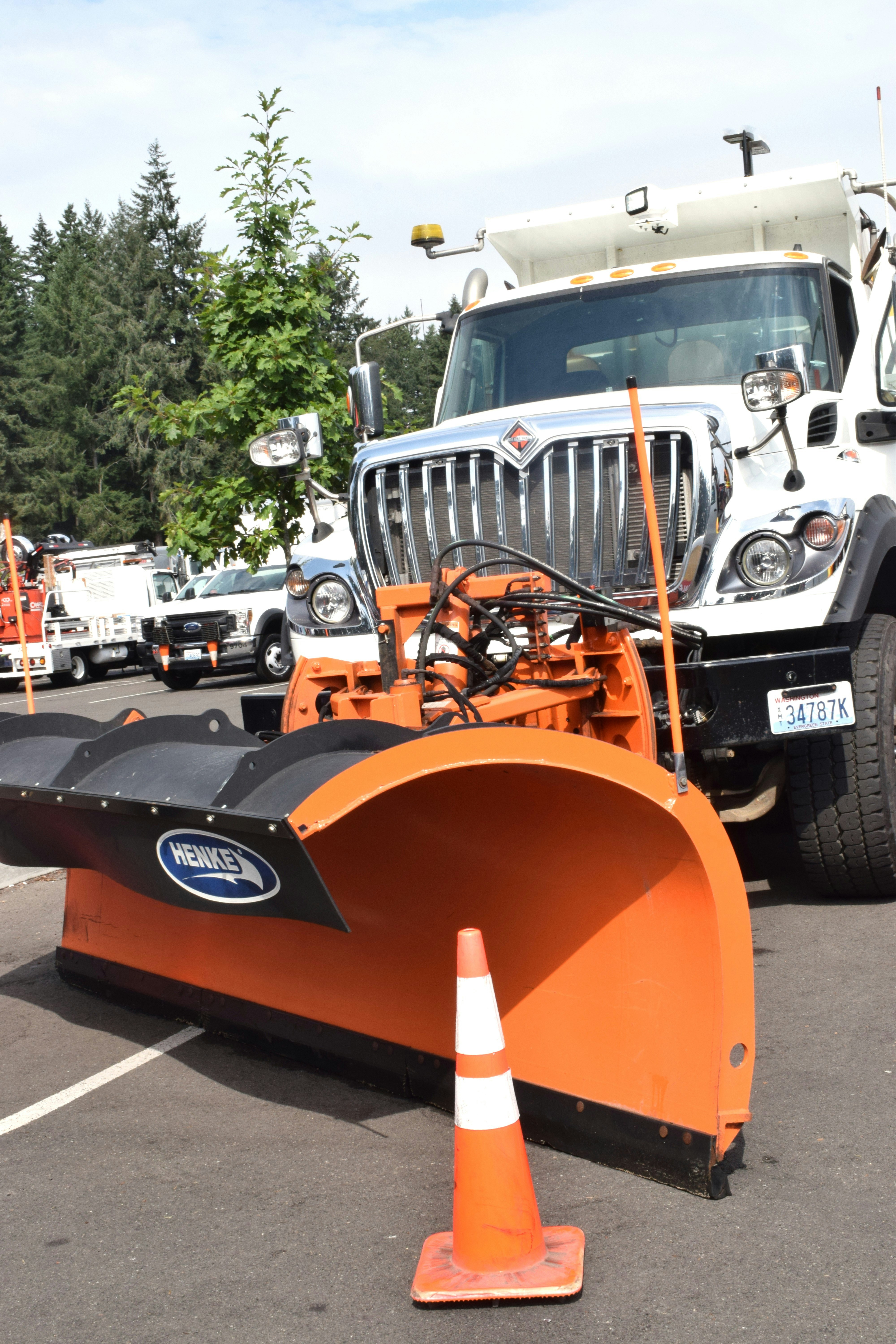 Chrome Grille Meets Field-Orange Snow Plow in a Parking Lot Showdown