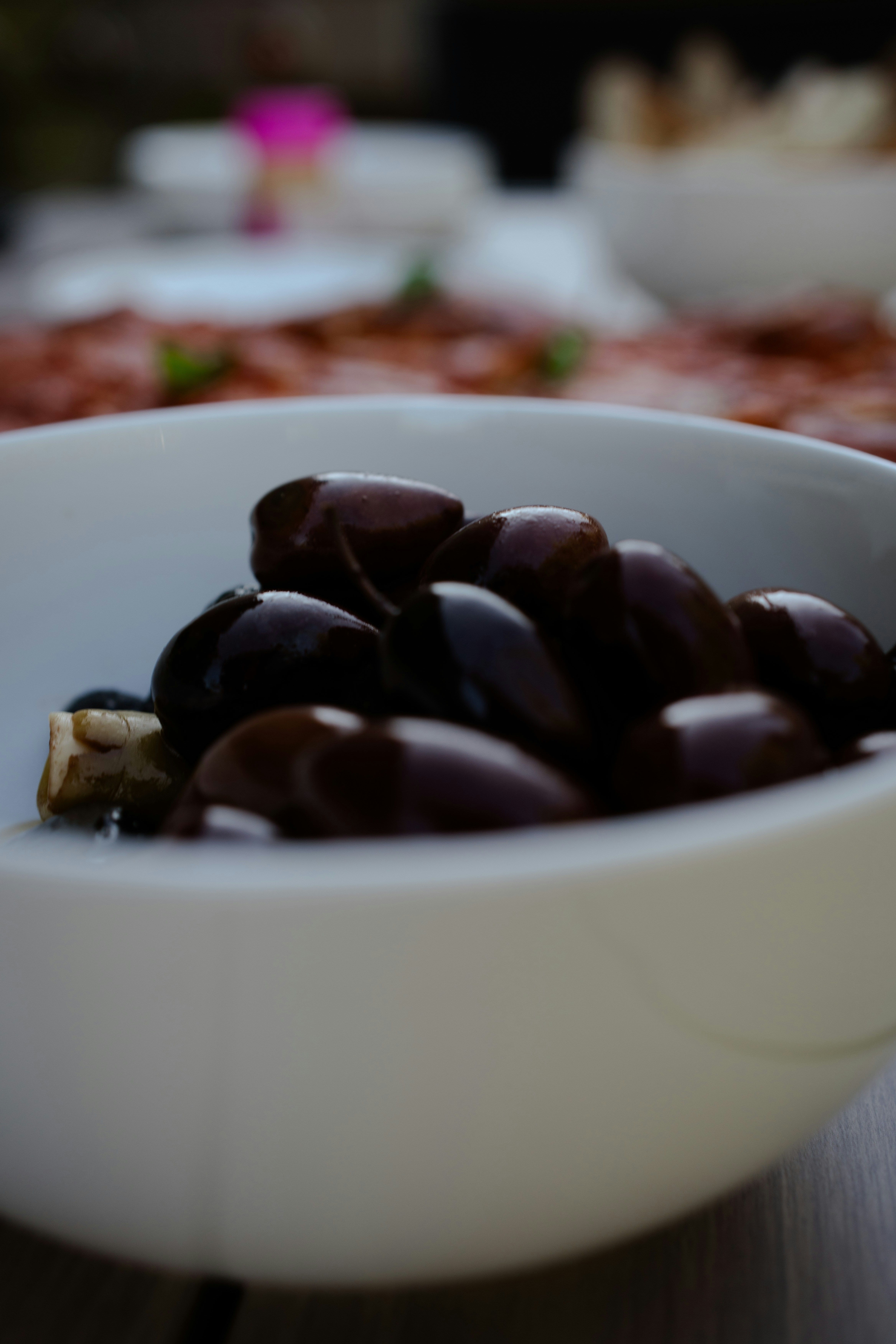Bowl of dark olives with blurred background