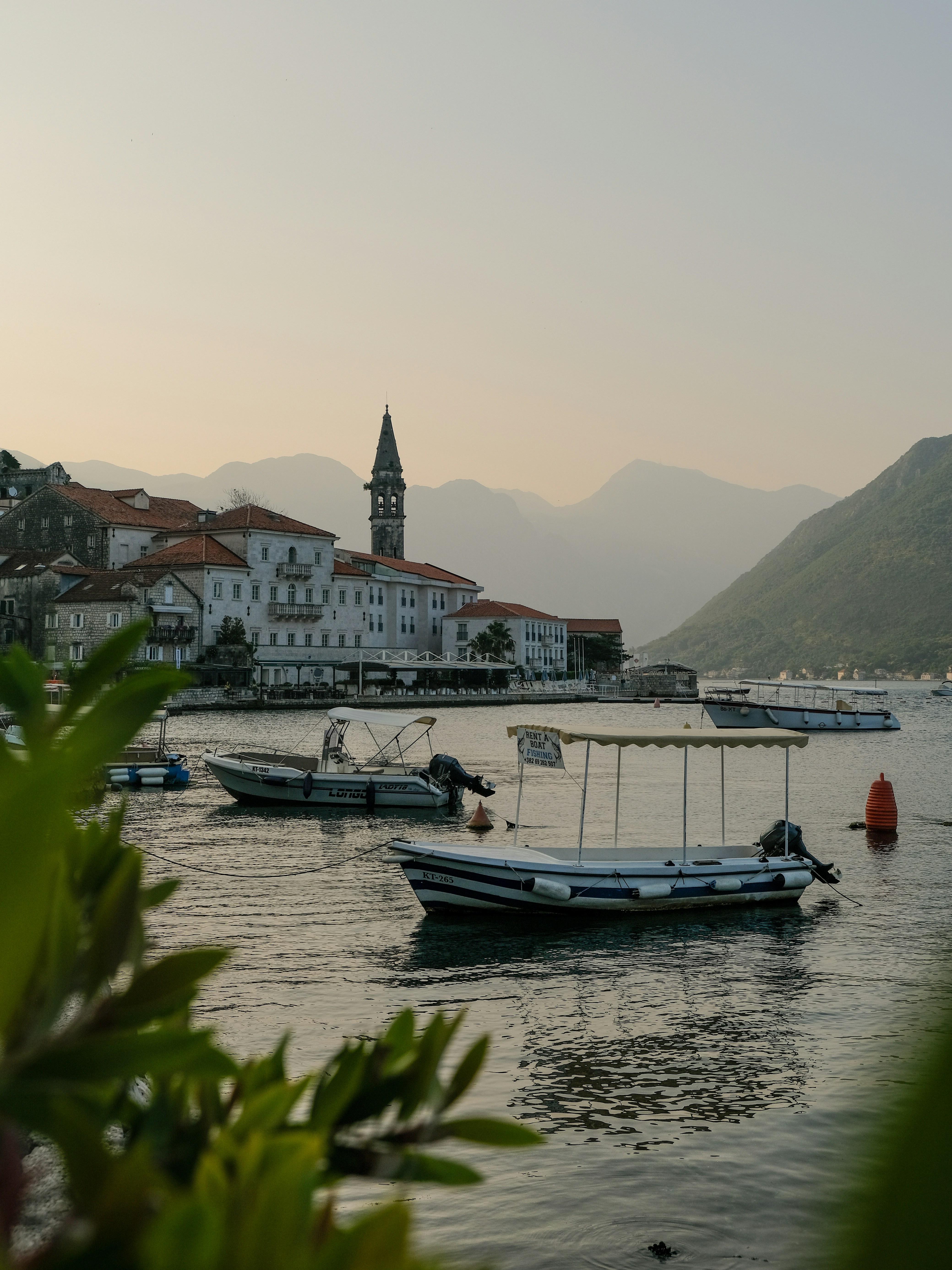 Boats float in a bay near a coastal town.