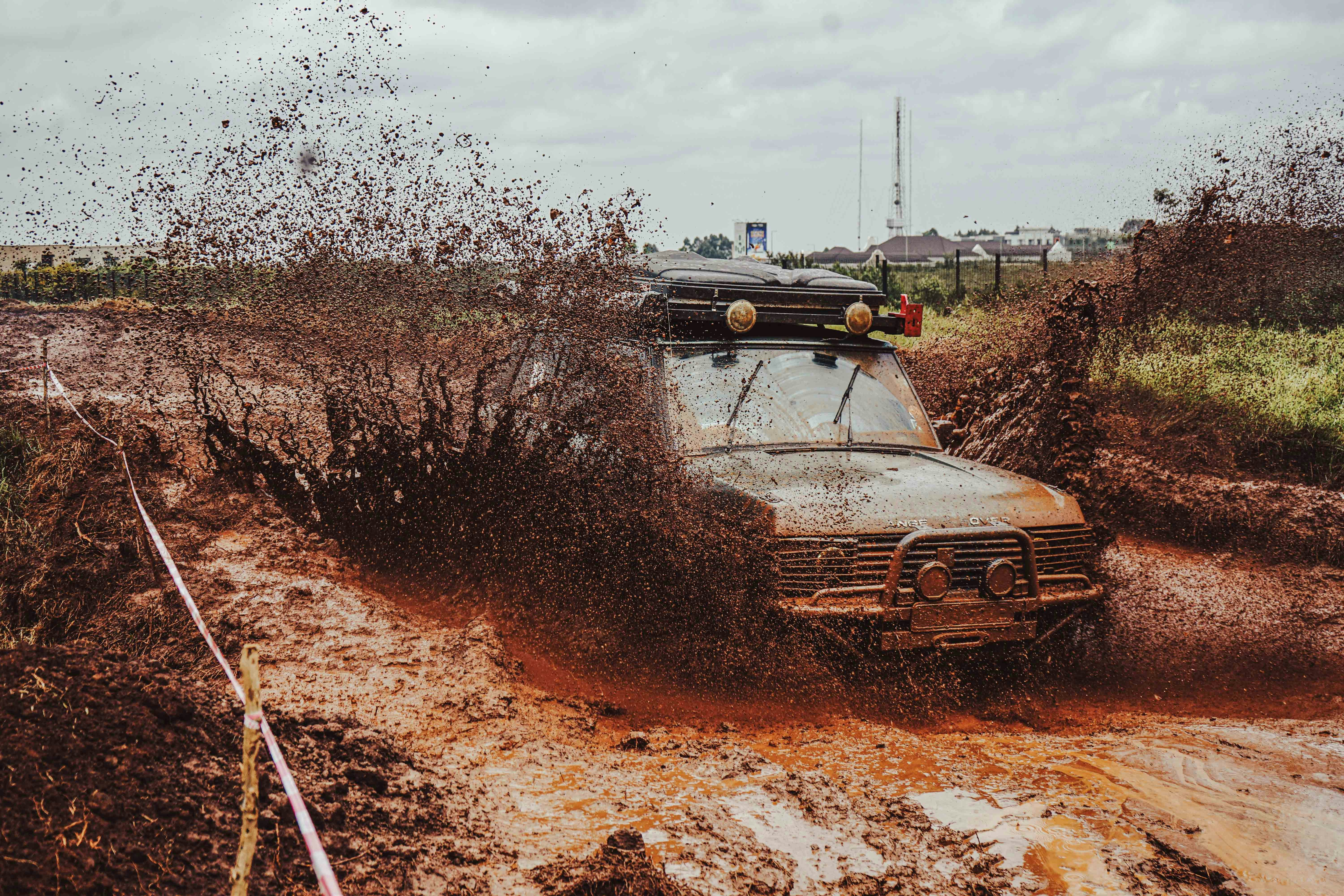 Mud-splashed Rally: A rugged old pickup powers through a churned clay obstacle