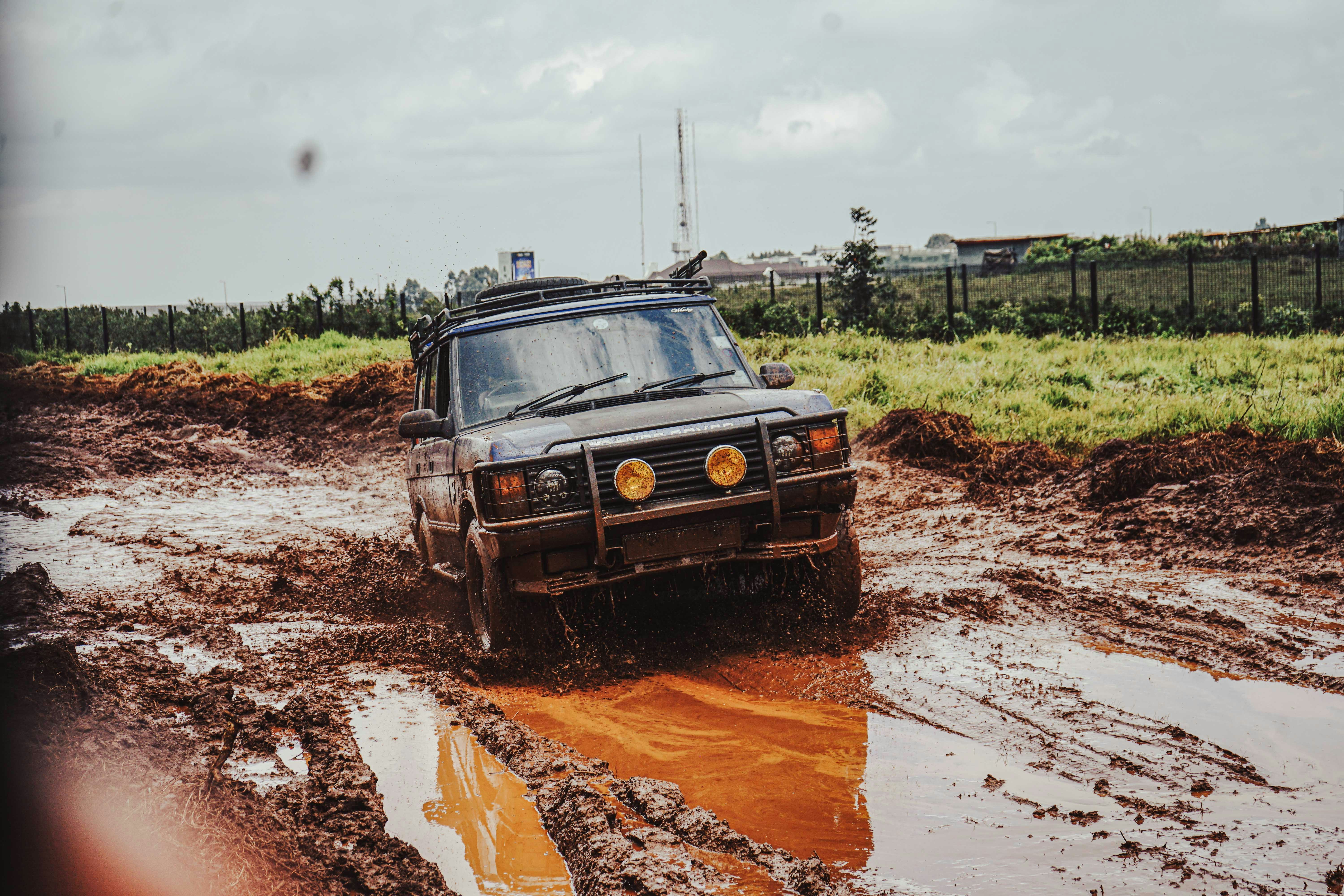 Mudbound Momentum: A Boxy 4x4 Clawing Through a Rutted Off-Road