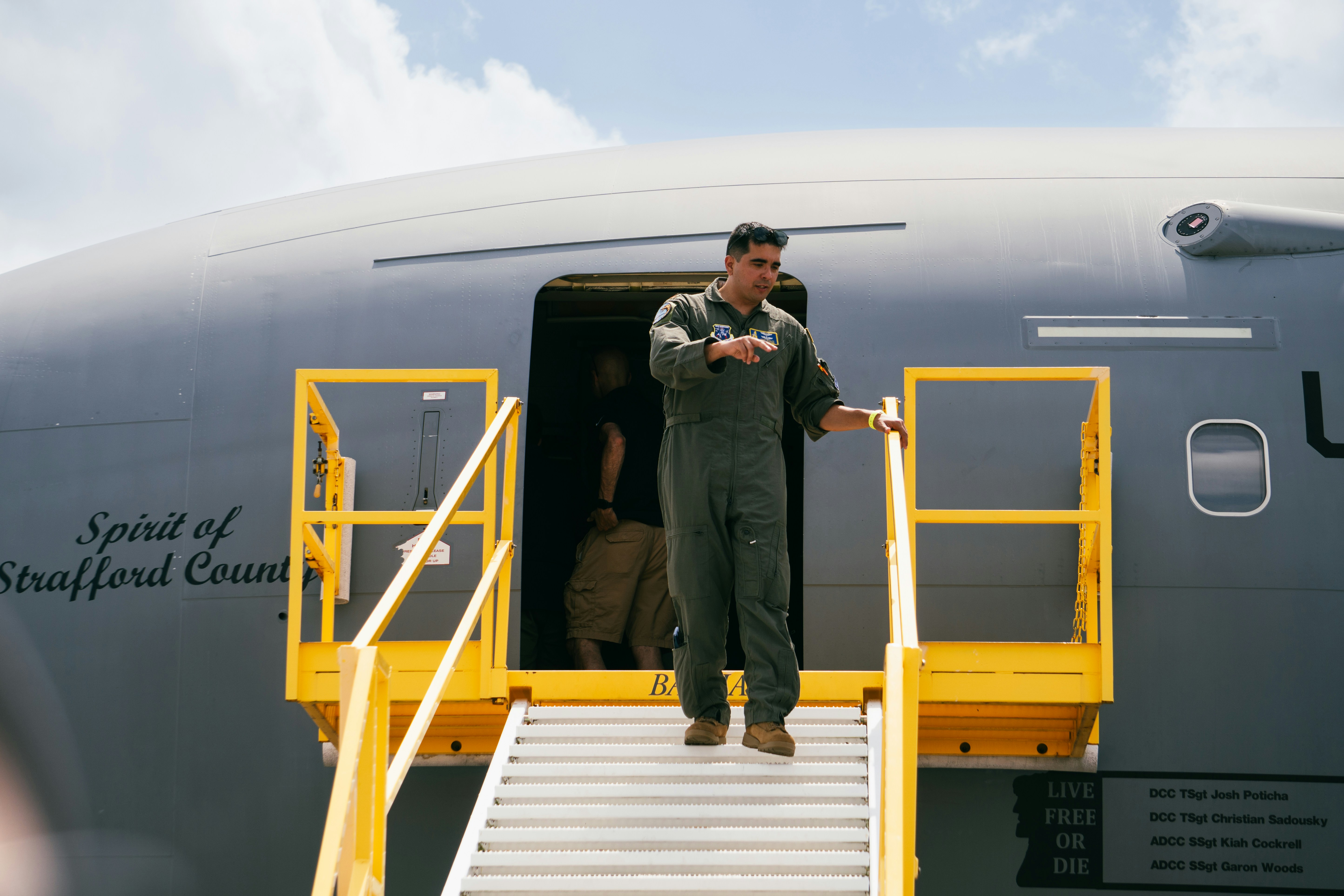 A military personnel descends the stairs from an aircraft, embodying the spirit of service and commitment.