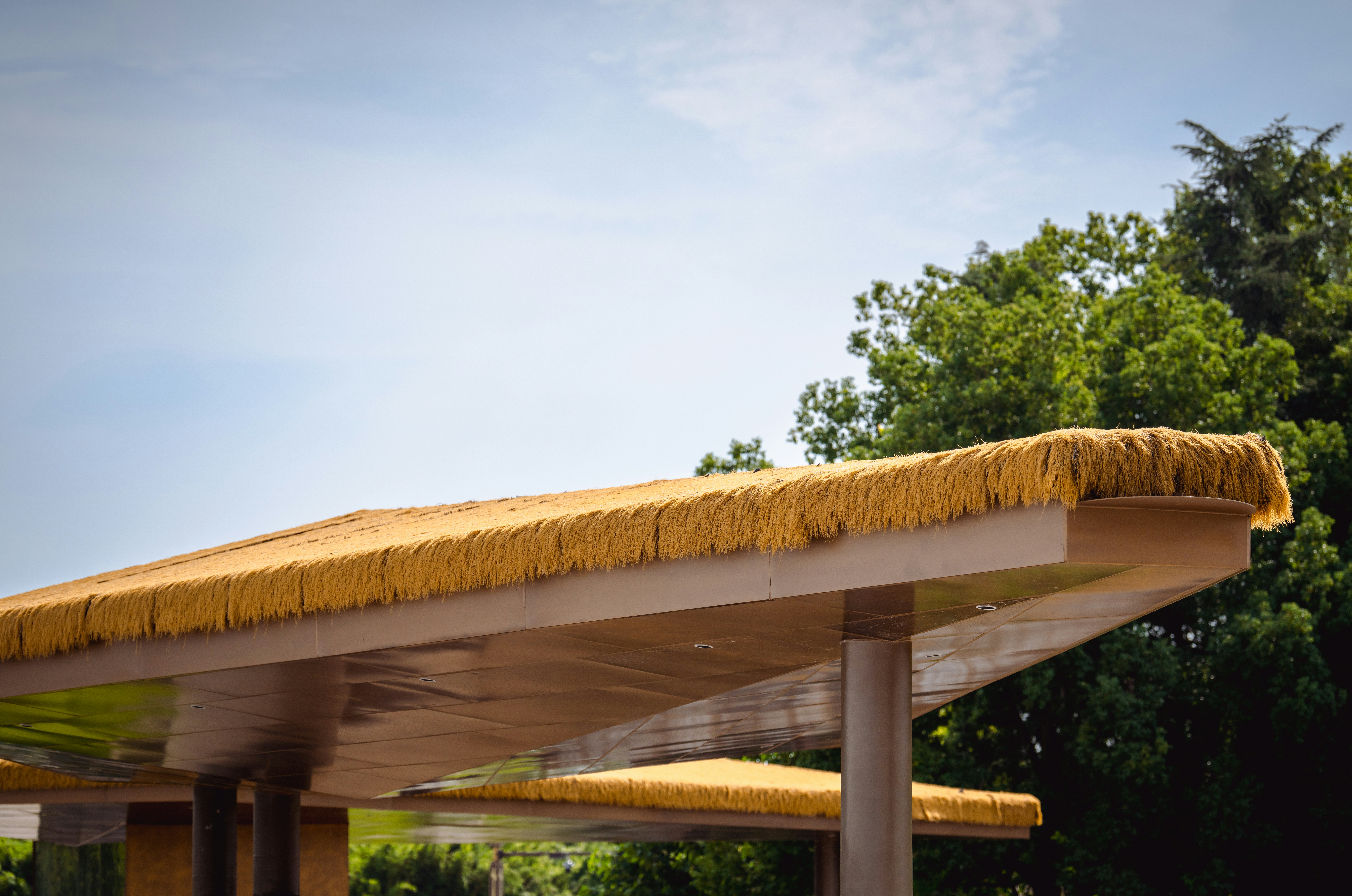 Thatched roof structure against a blue sky