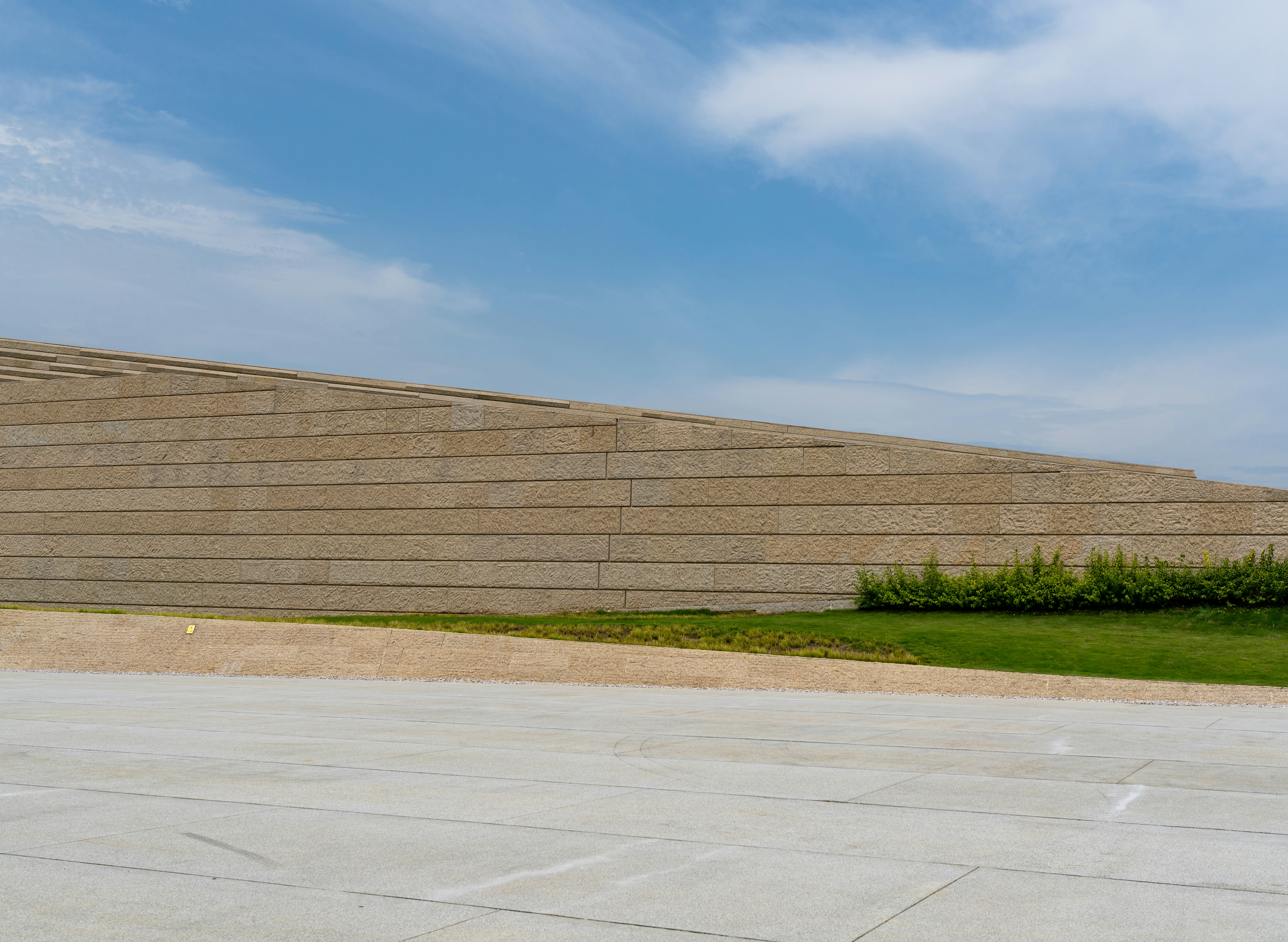 A concrete wall with grass and blue sky