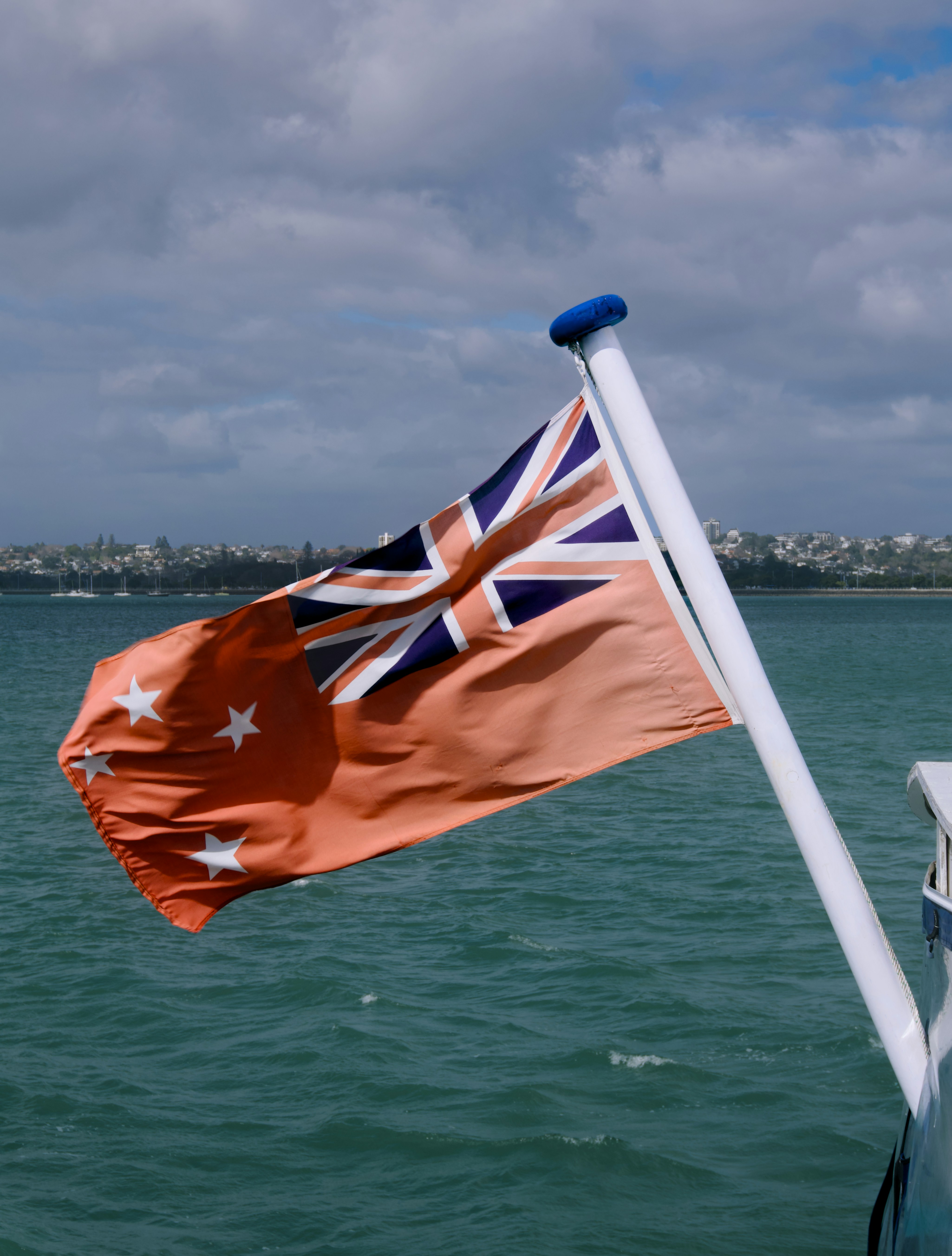 Orange flag with stars flying over the ocean photo – Free New zealand ...