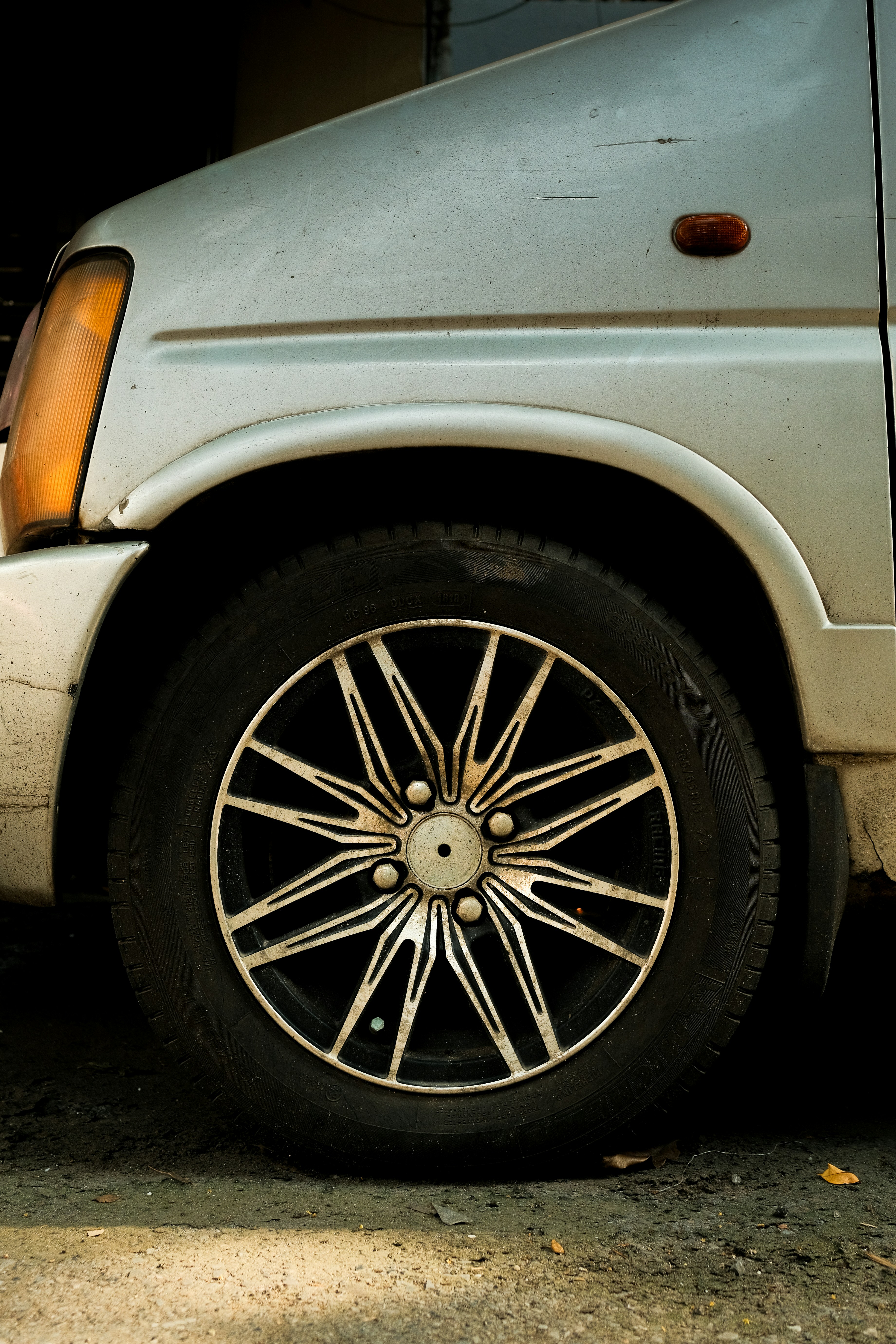 Close-up of a silver car wheel with alloy rims.