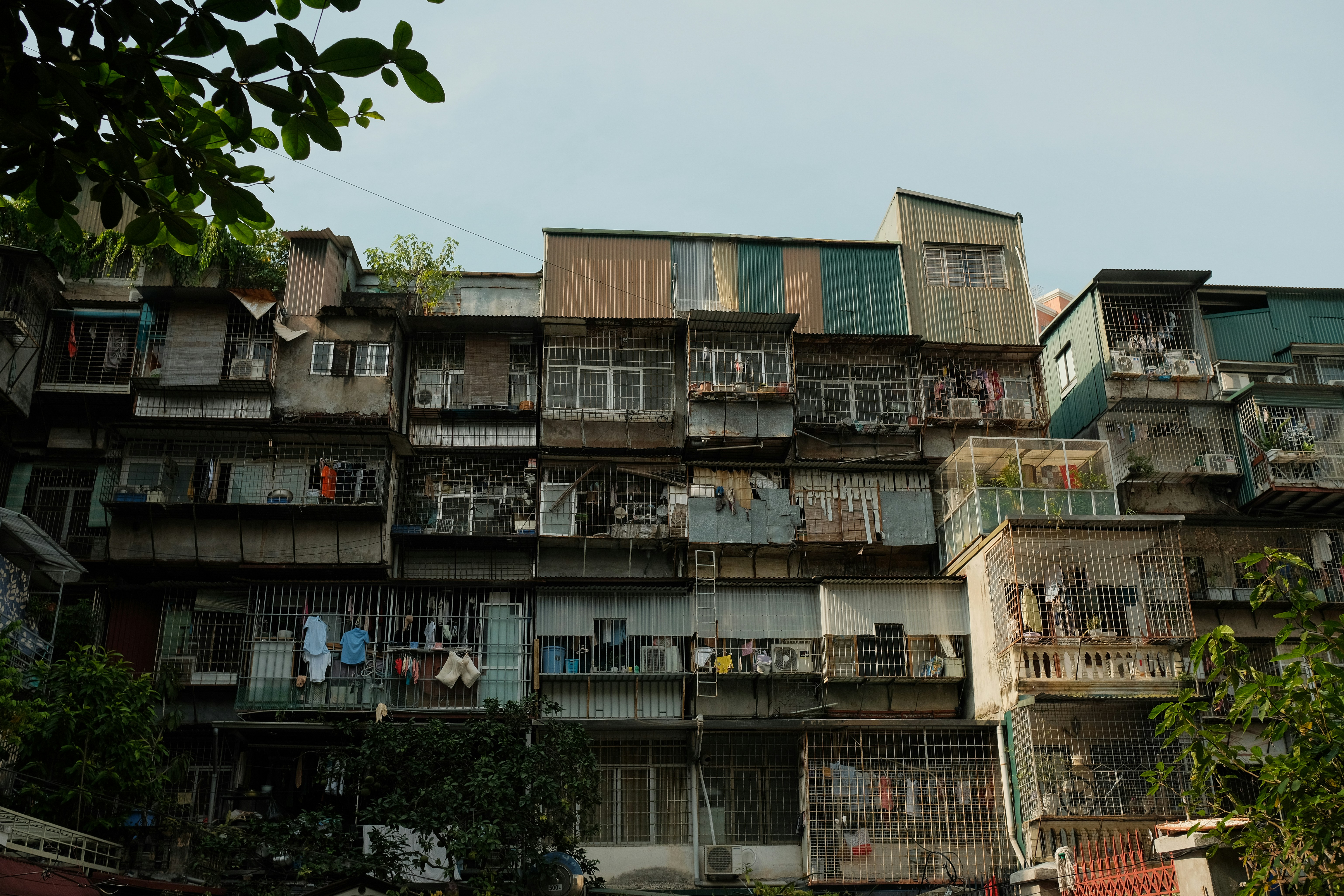 Overcrowded apartment buildings with many balconies and windows.