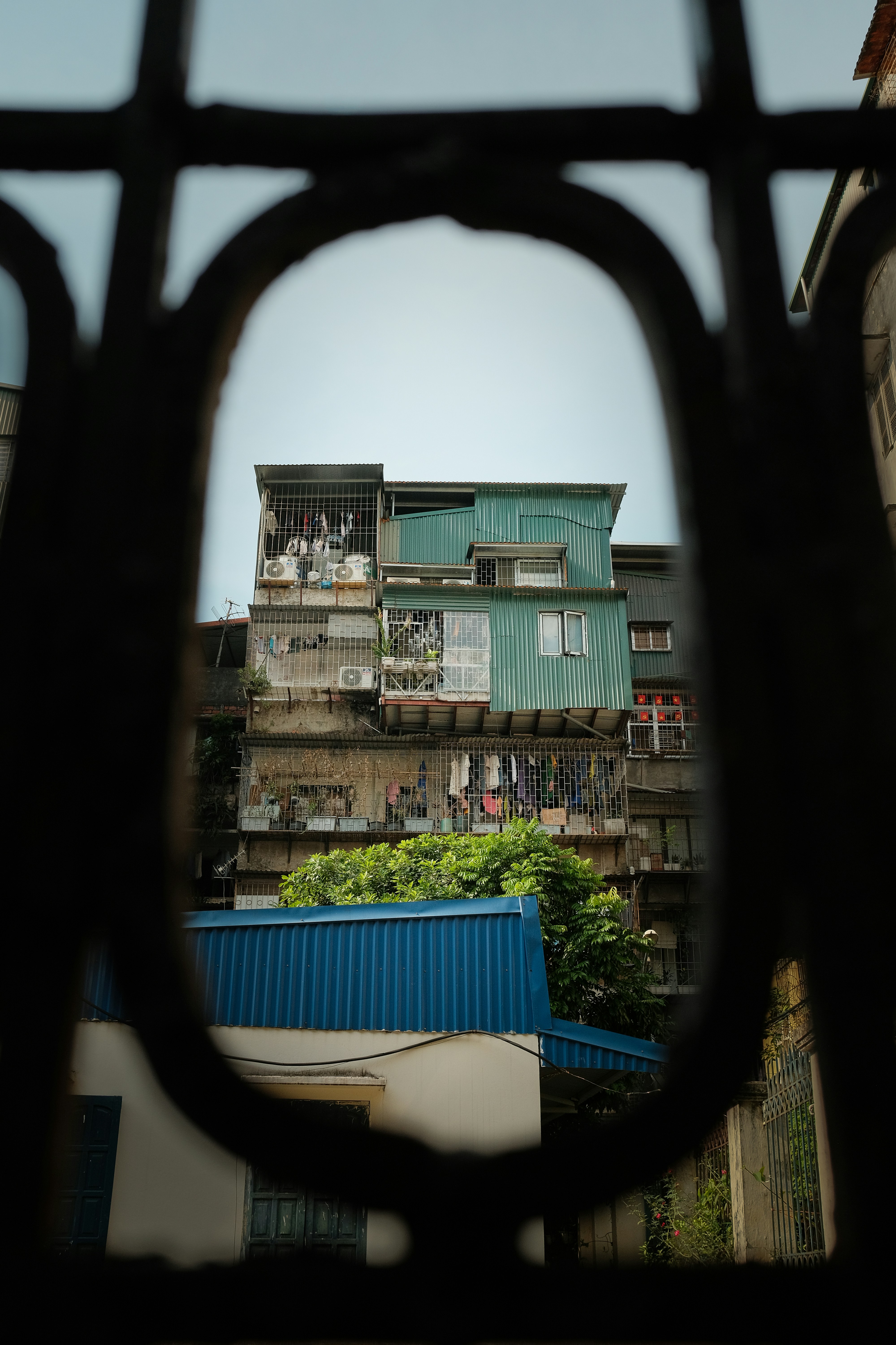 Apartment buildings seen through a decorative metal grate.