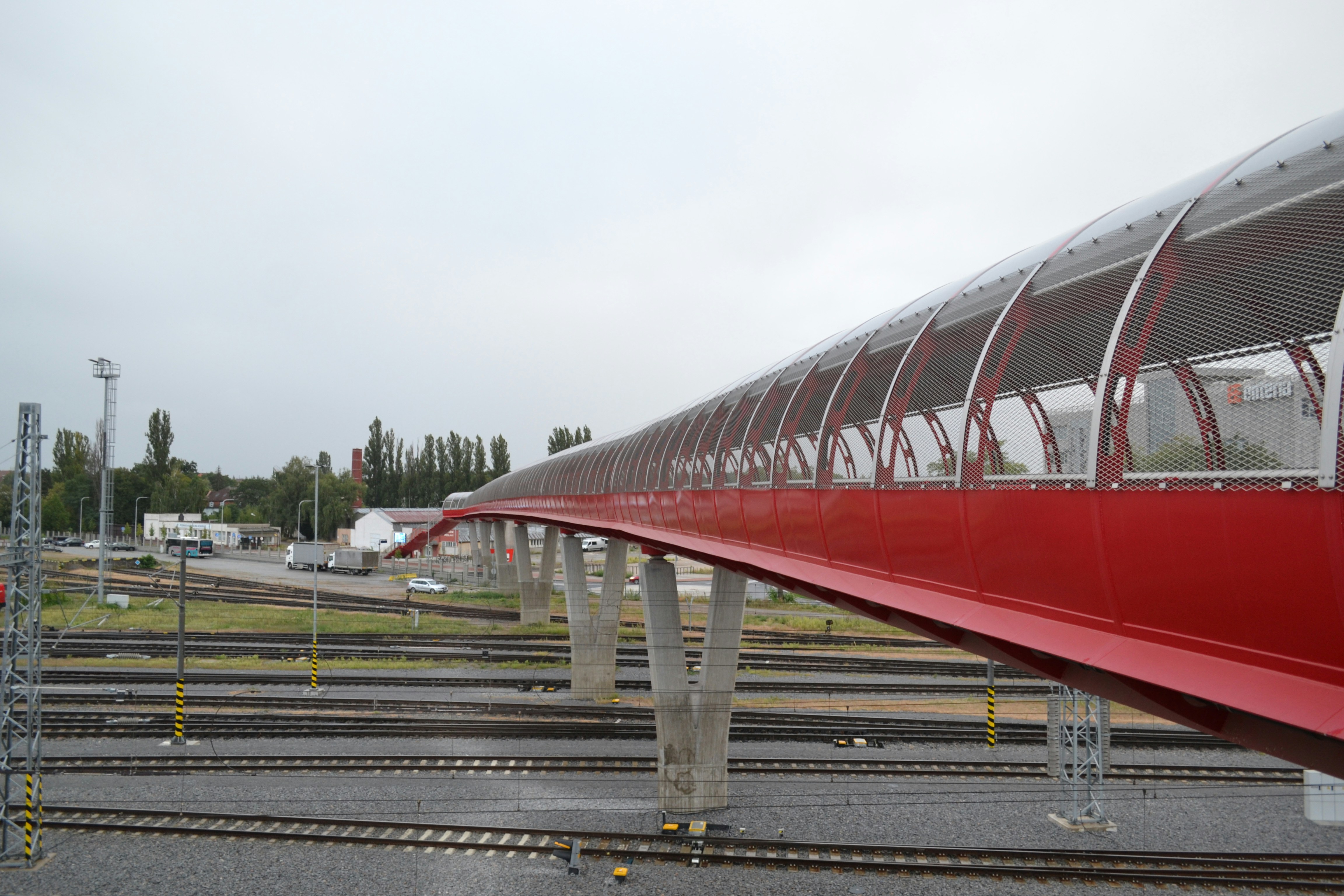 Modern red pedestrian bridge over train tracks