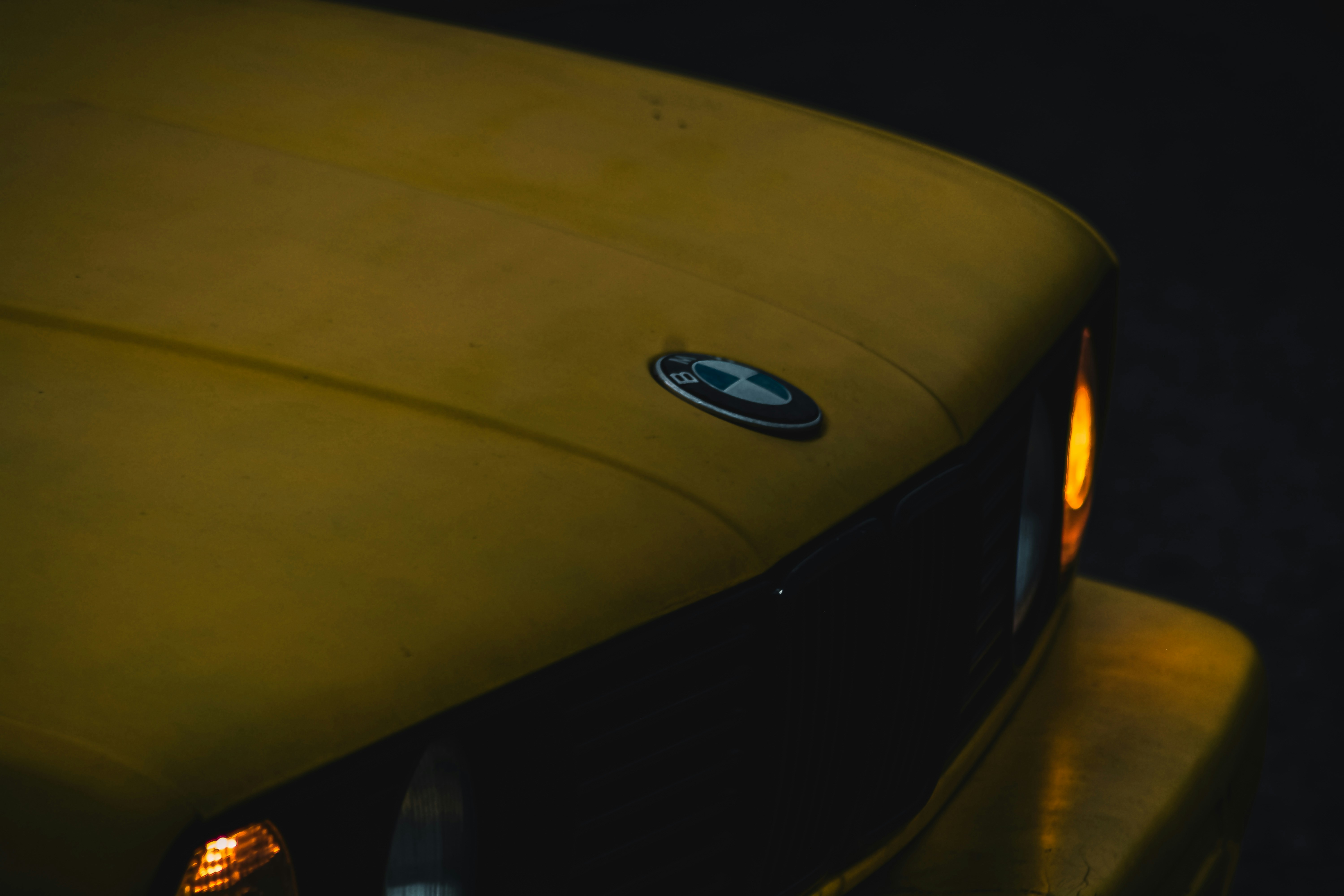 Close-up of a yellow car's front emblem.