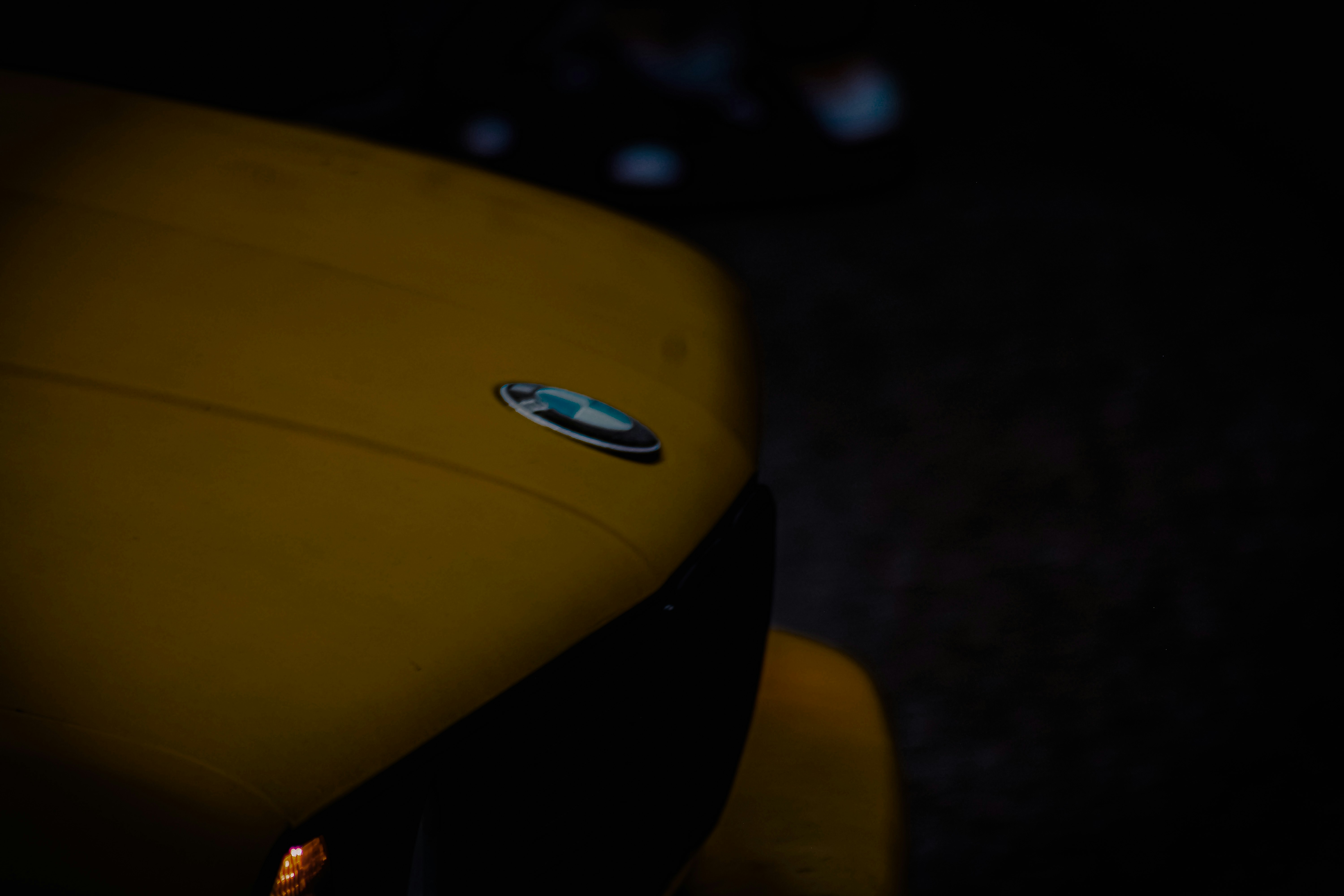 Close-up of a yellow car's emblem