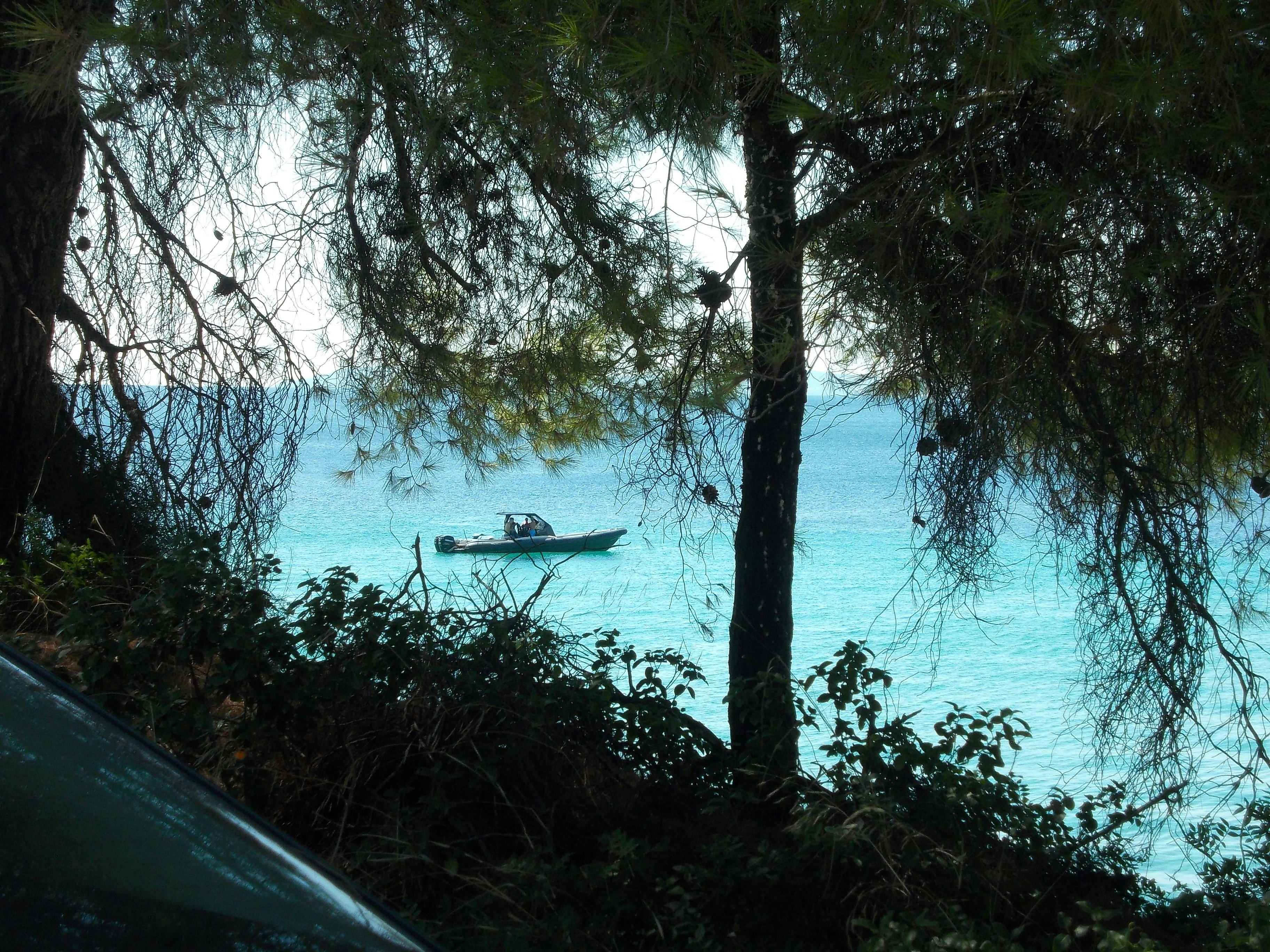 from my perspective: | A lone boat floats on a turquoise sea.