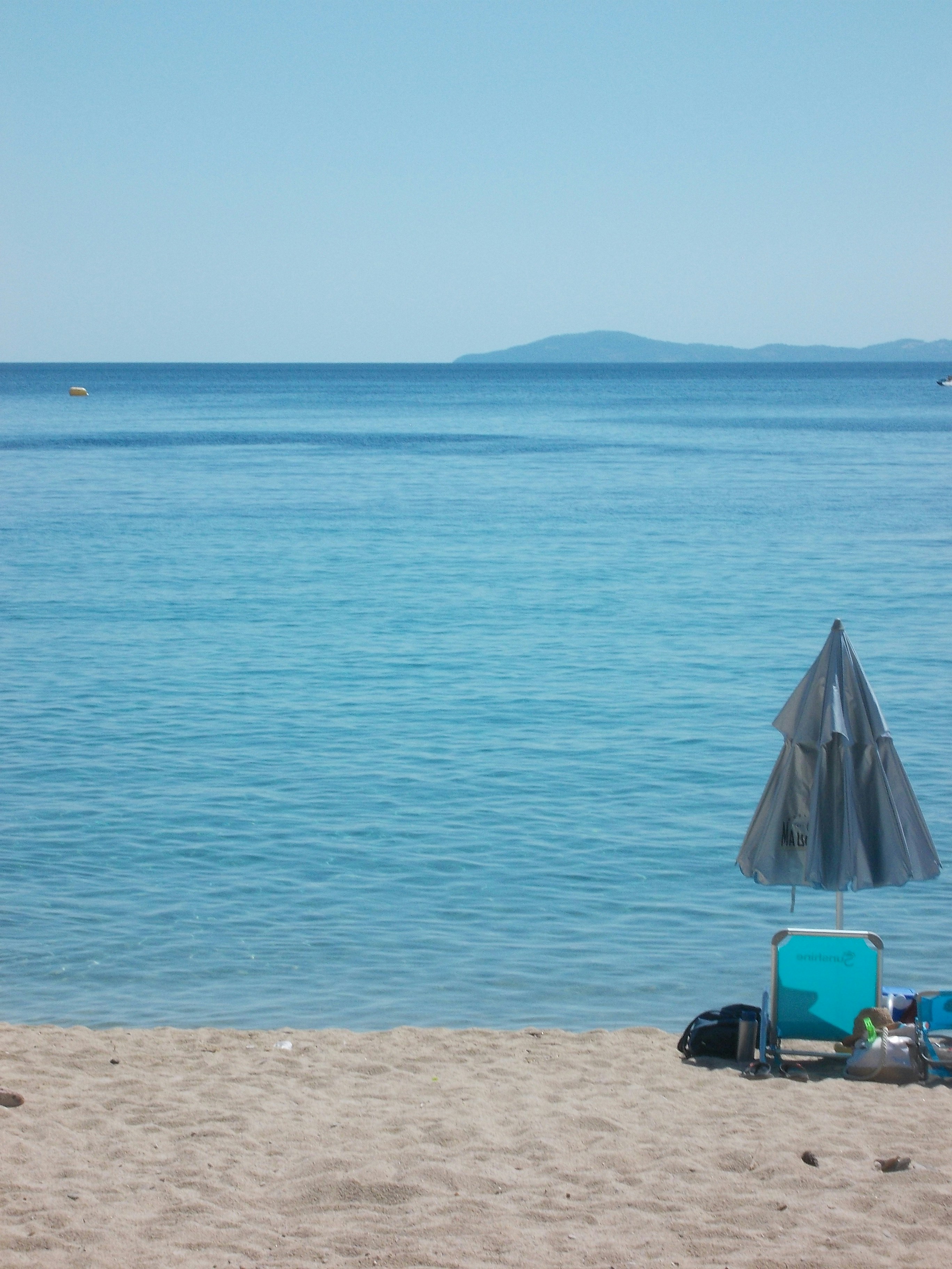 Beach chairs and umbrella by the calm blue ocean