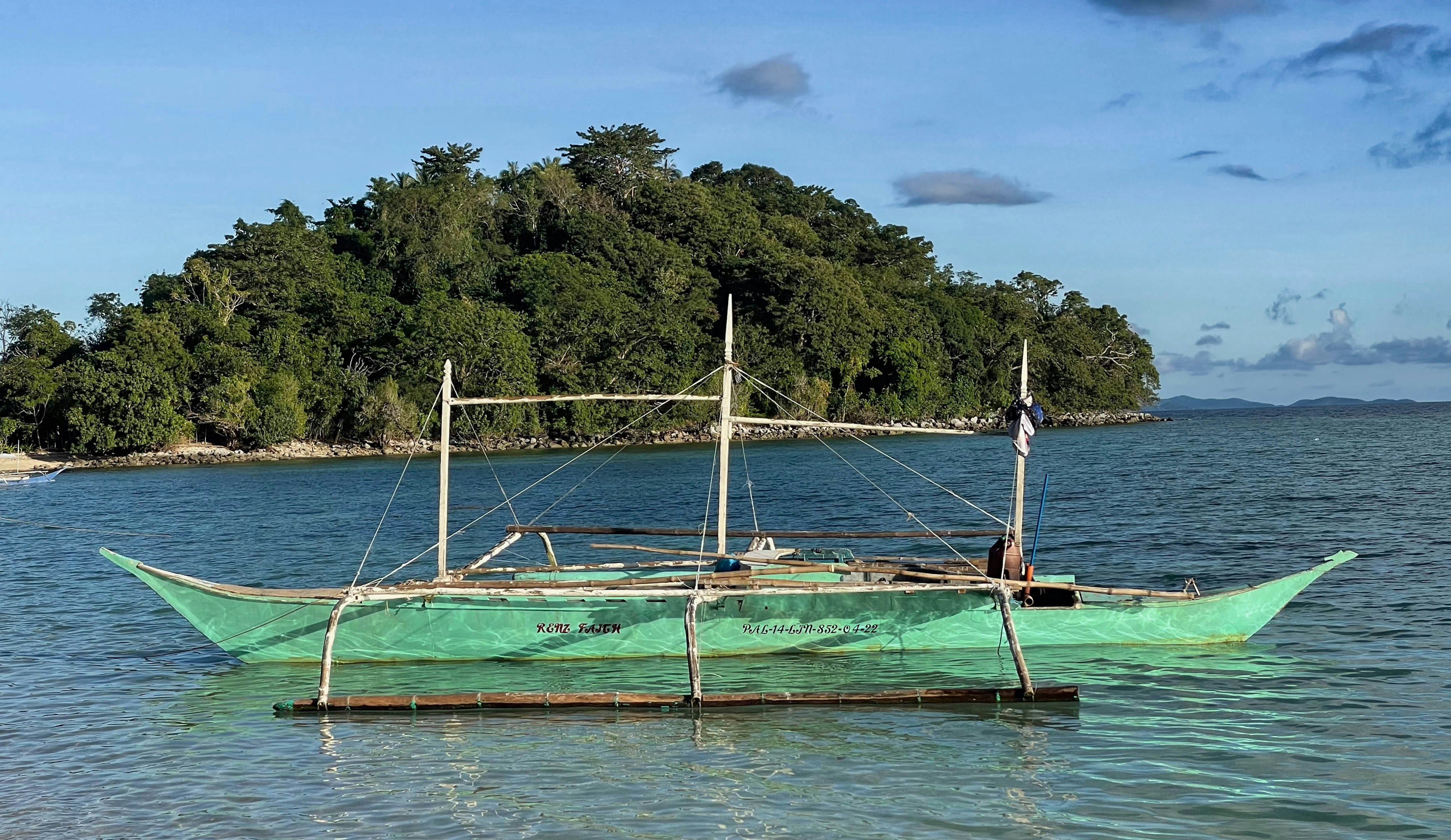 Green Boat at the Edge of a Calm Tropical Shore