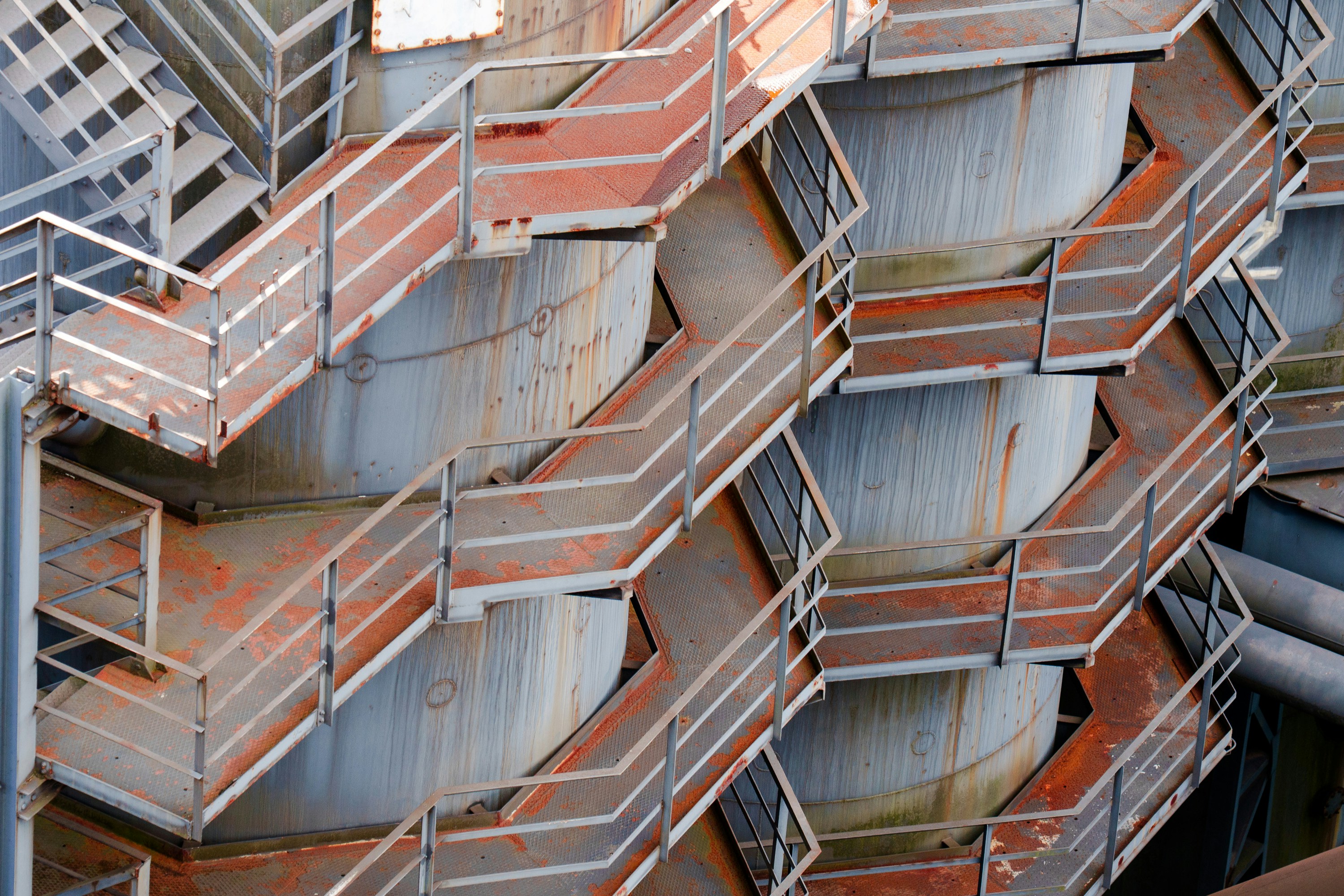 Industrial metal stairs winding around cylindrical structures photo ...