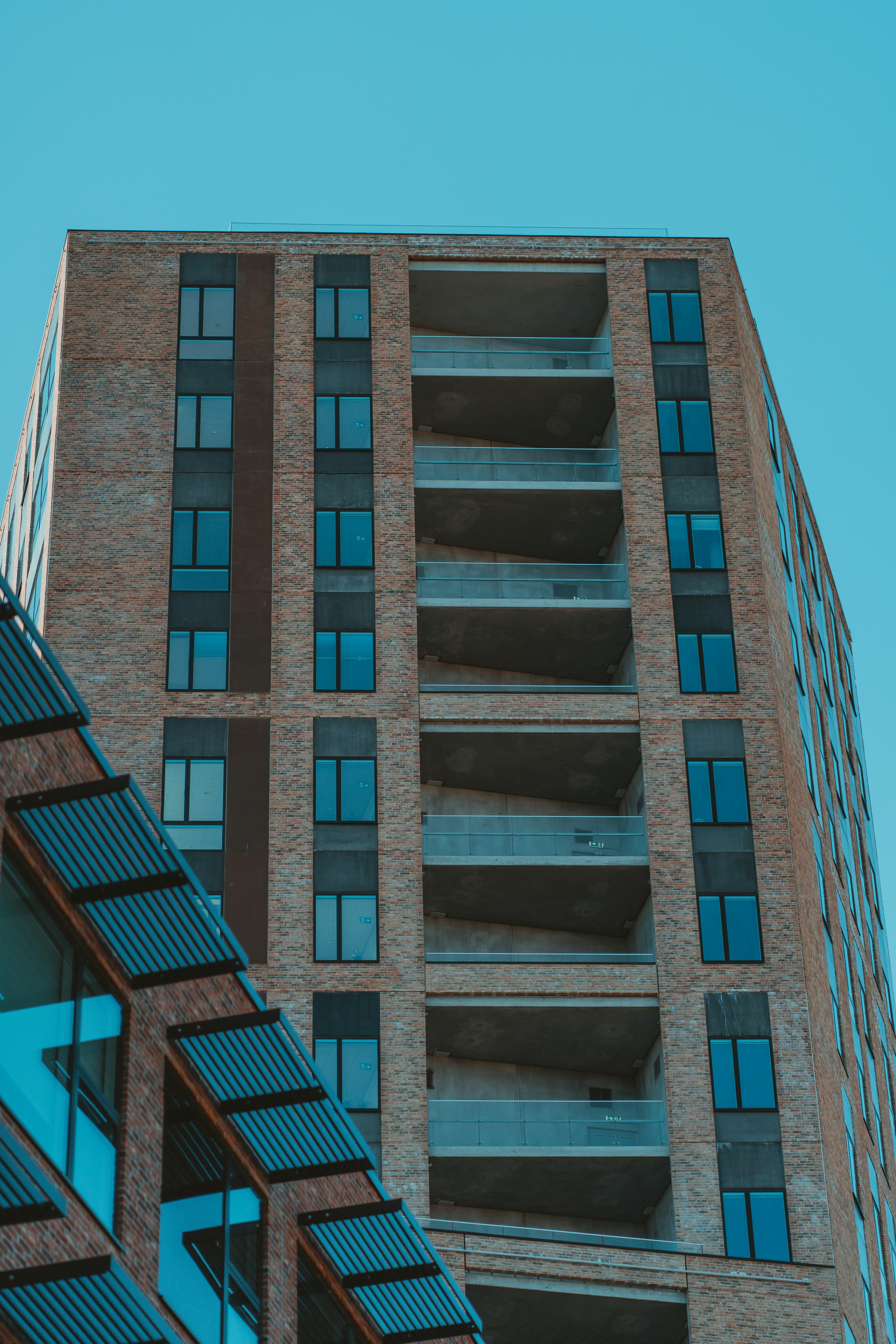 Modern brick building with balconies against blue sky