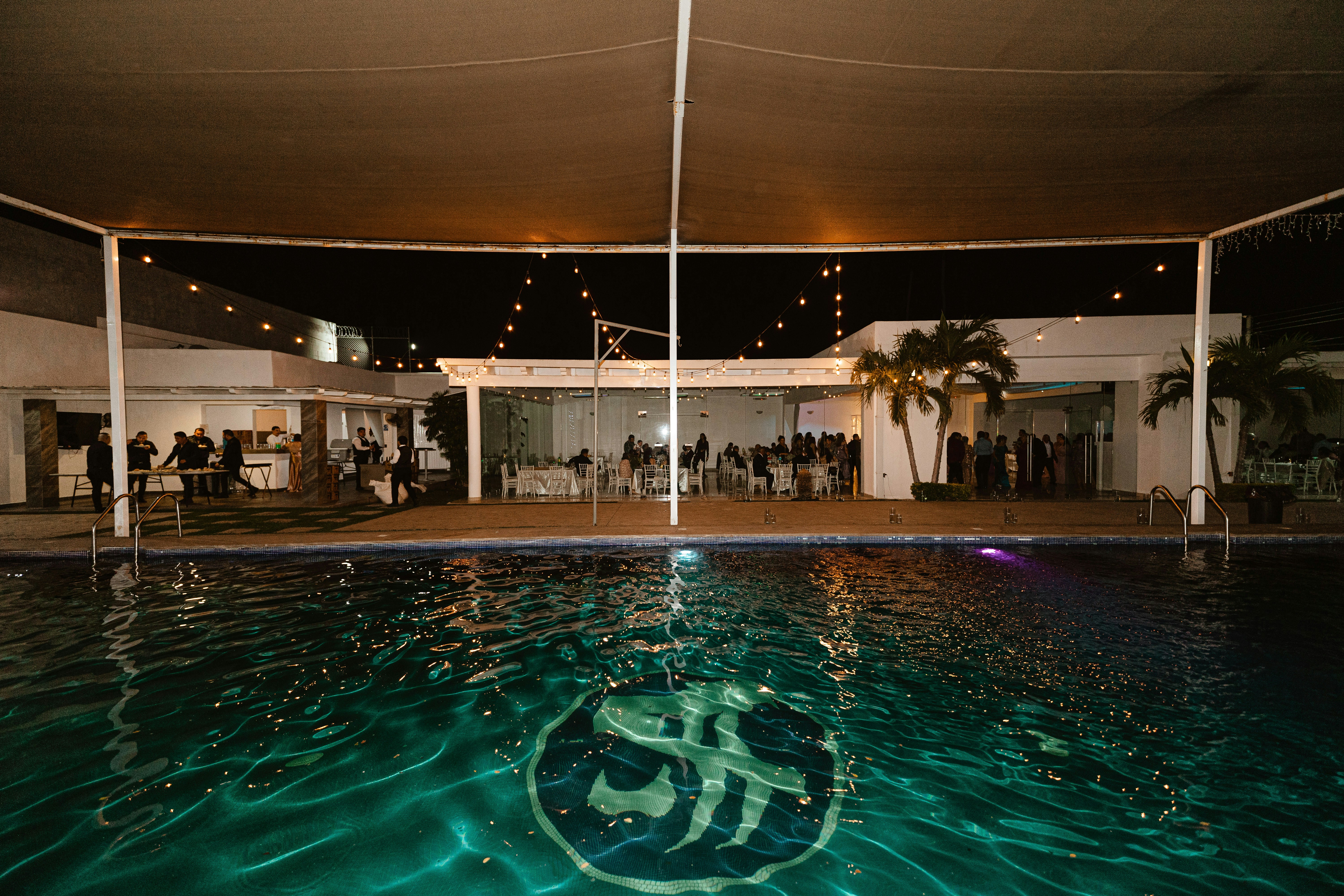 Poolside event venue with string lights at night. photo – Free Pastel ...