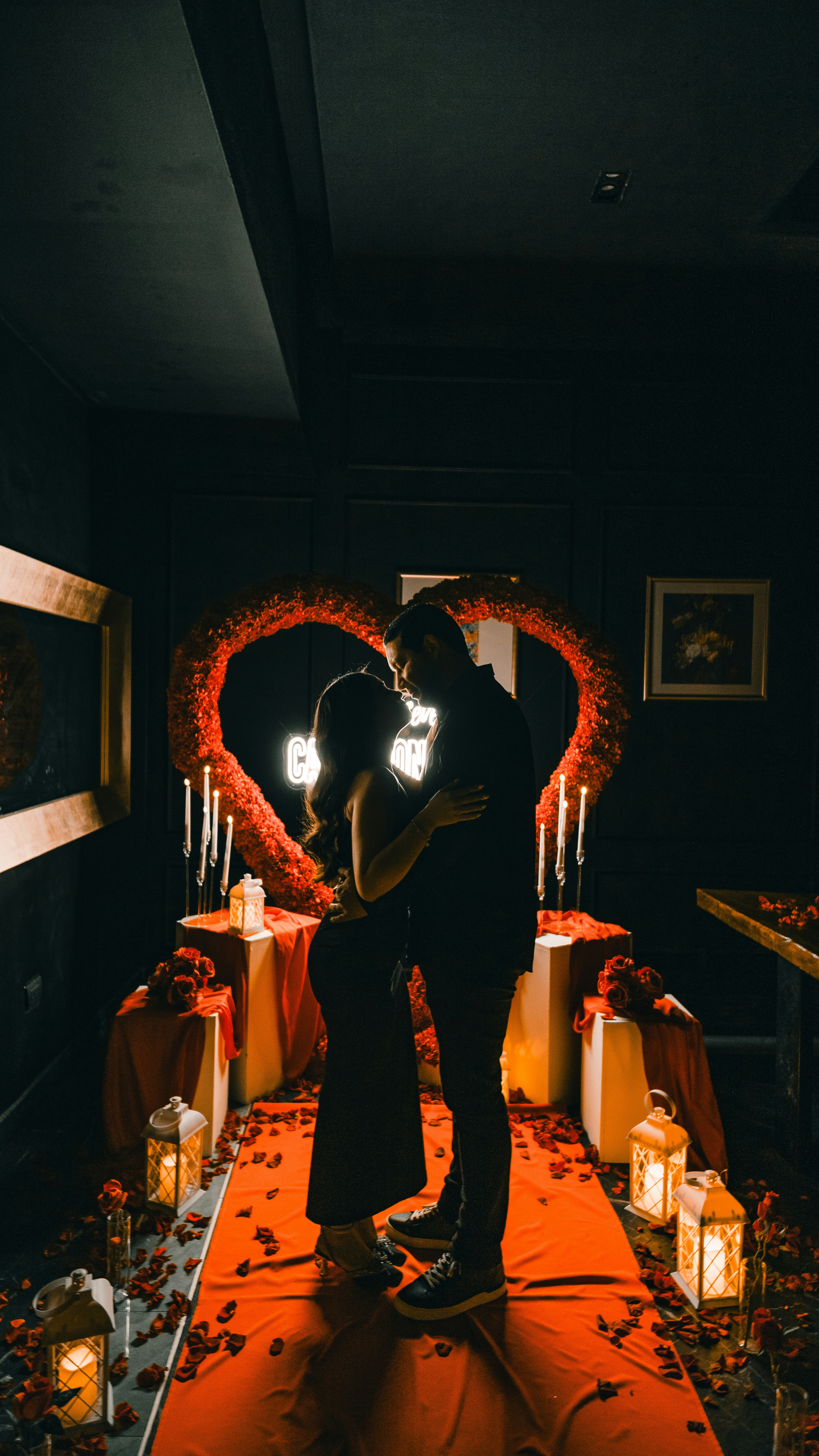 Couple embracing in front of a heart-shaped decoration