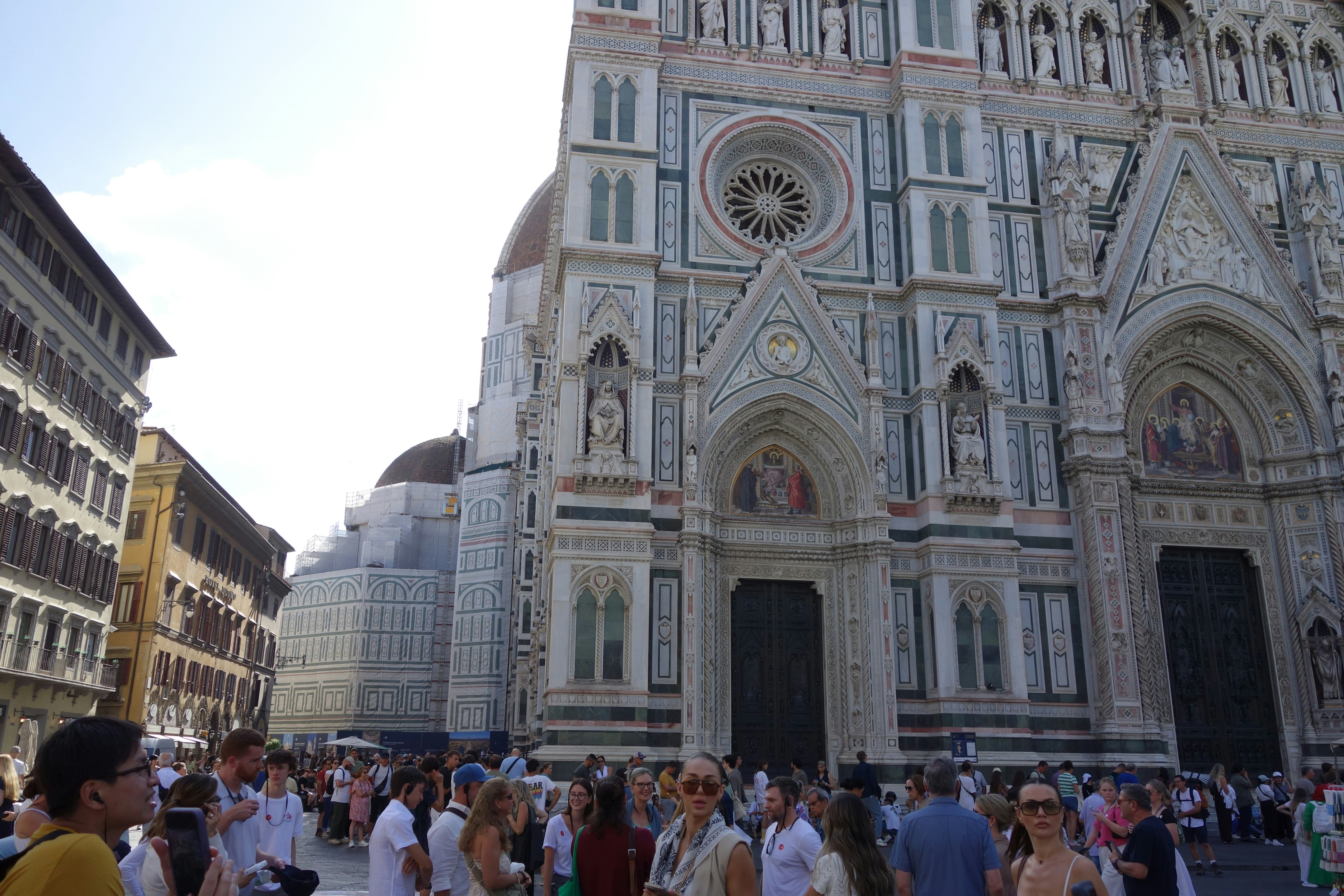 Crowded plaza in front of ornate renaissance cathedral
