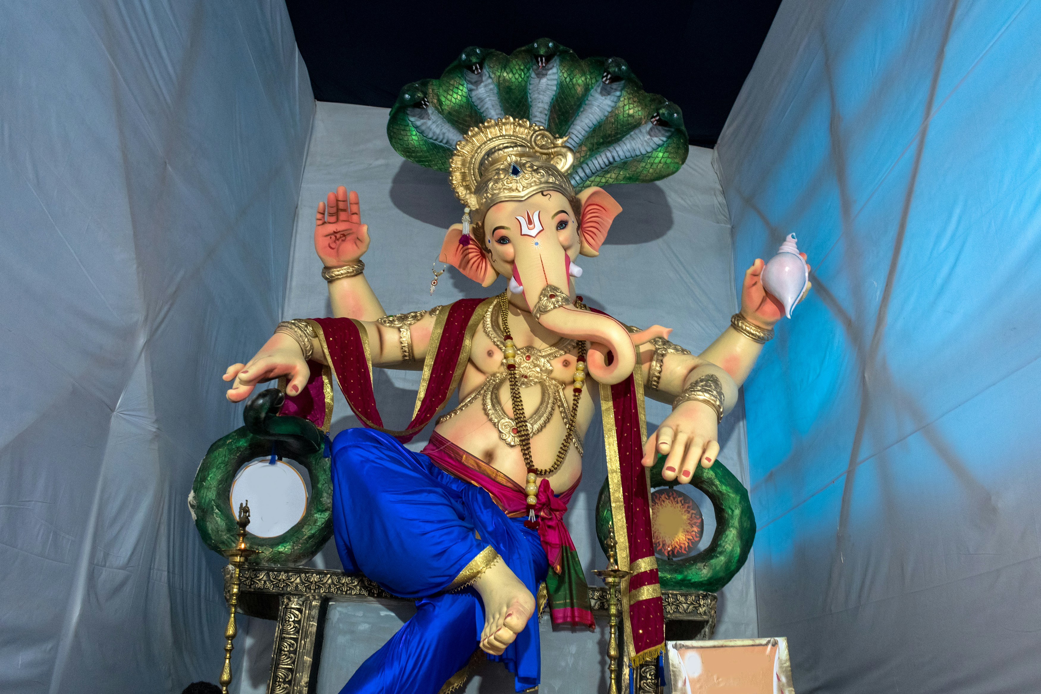 A statue of the hindu deity ganesha sits on a throne. photo – Free ...