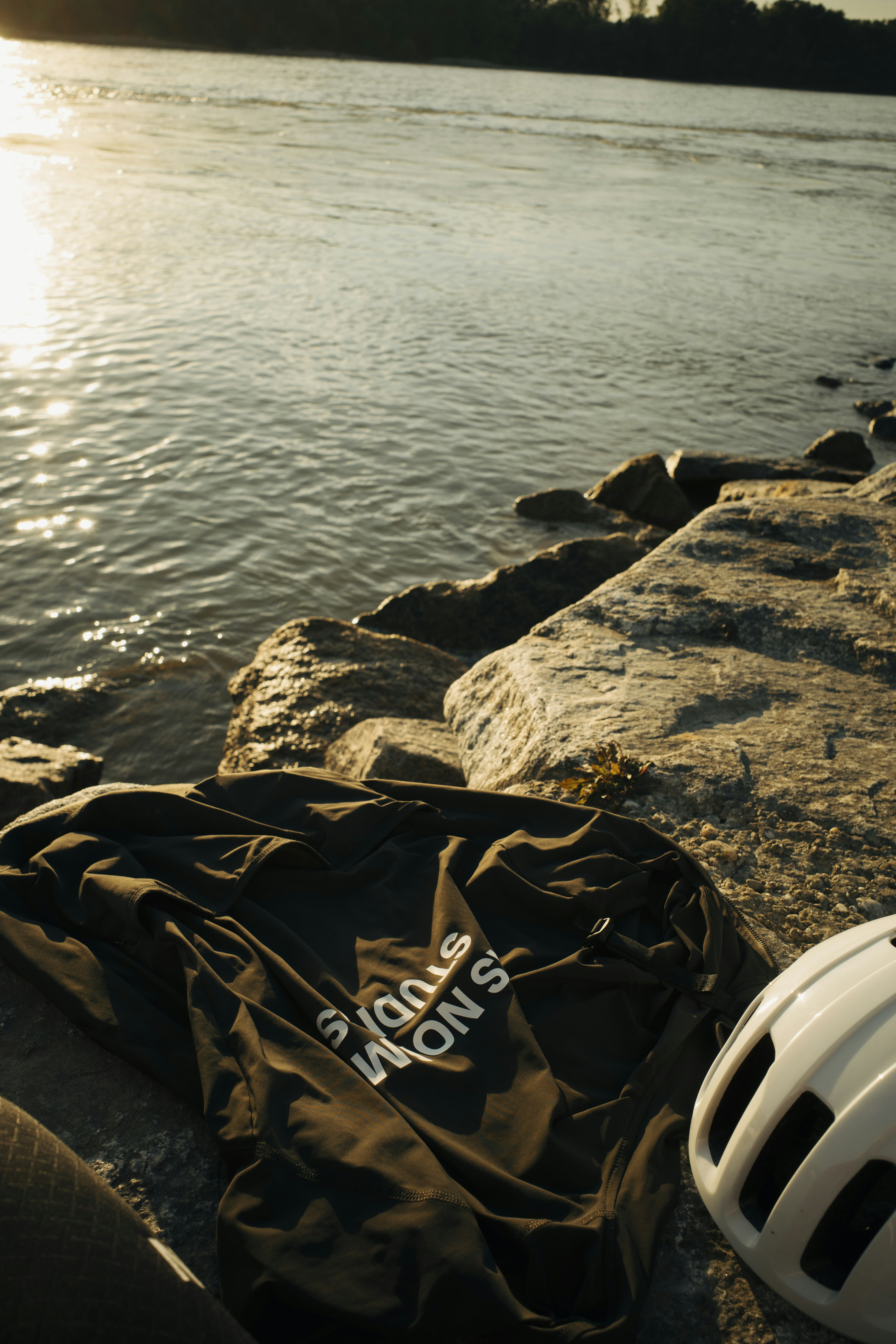 Golden Hour Tranquility by the Seawall: Helmet and Rocks