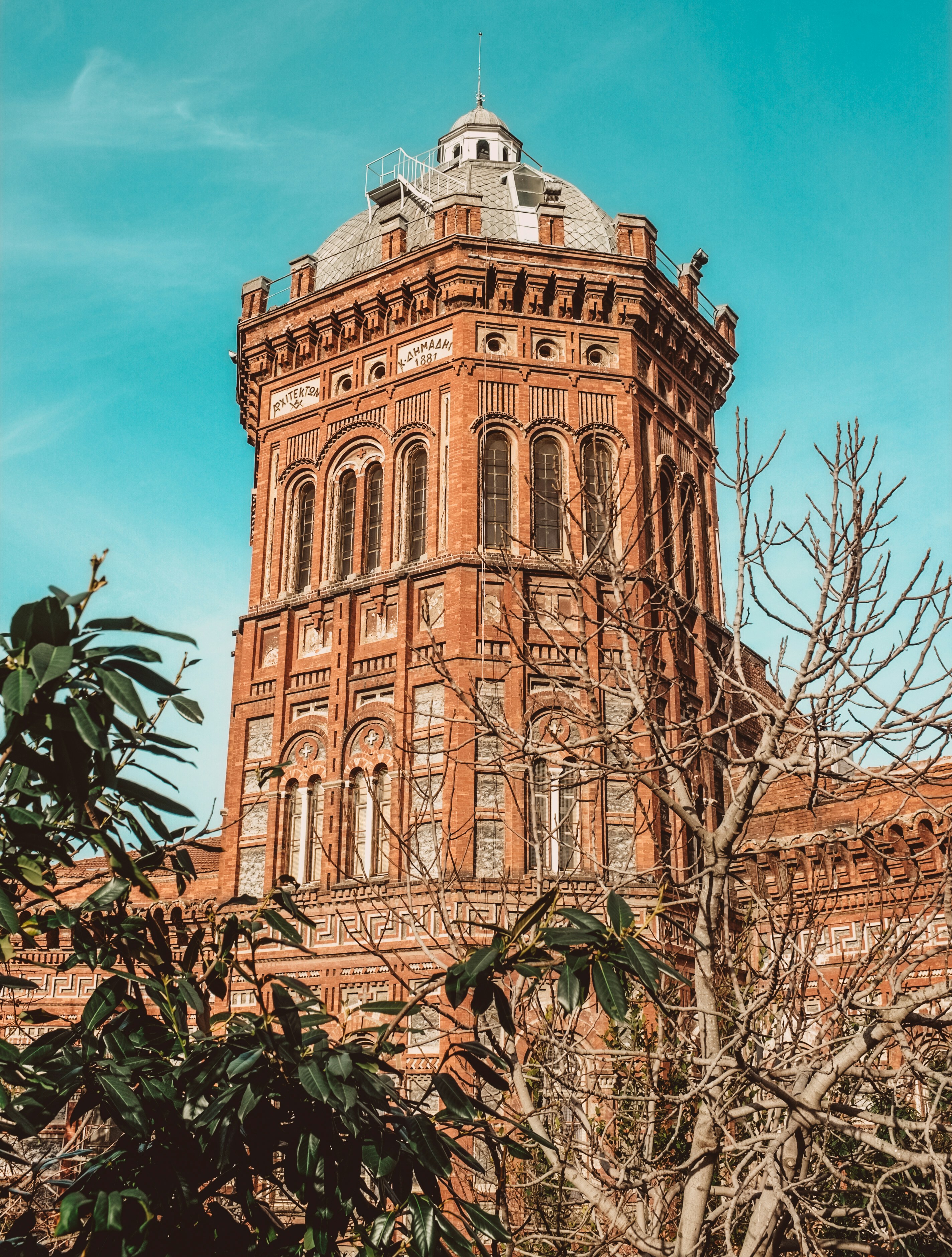 Phanar Greek Orthodox College | Ornate brick tower with arched windows against blue sky