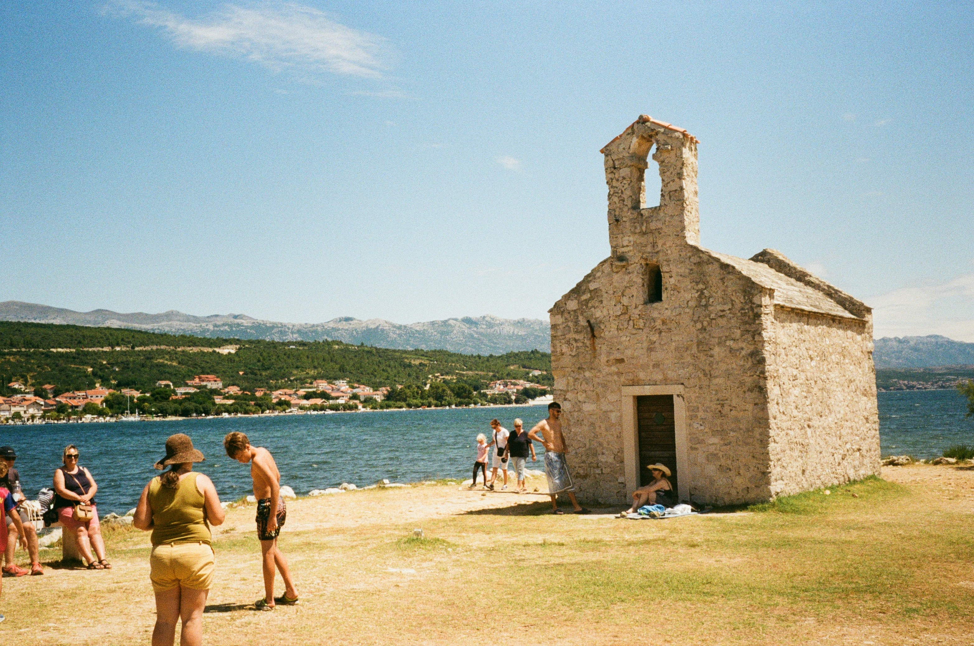 Kodak pro image 100 | Small stone church by the sea with people