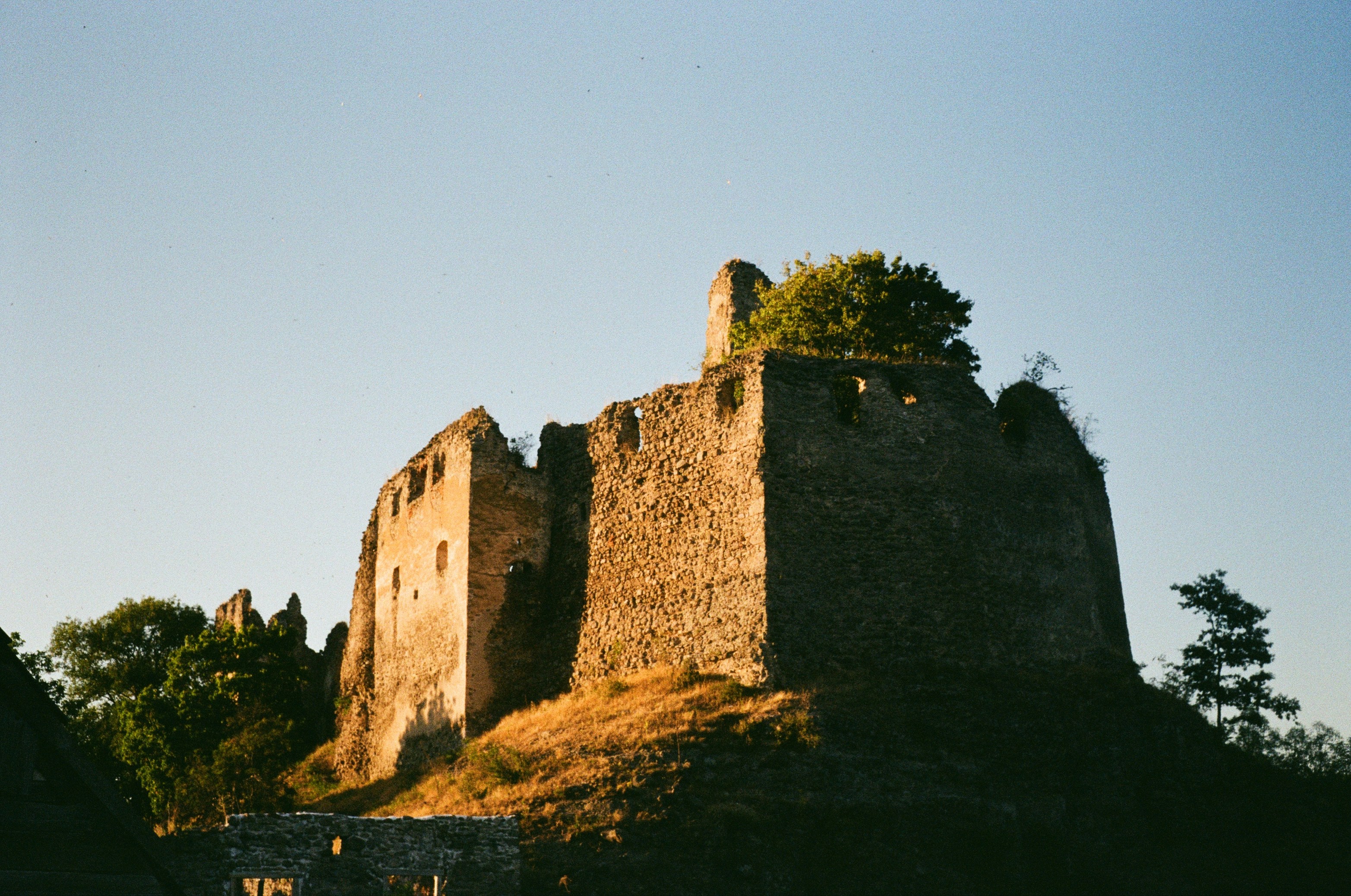 Ancient stone castle ruins on a grassy hill.
