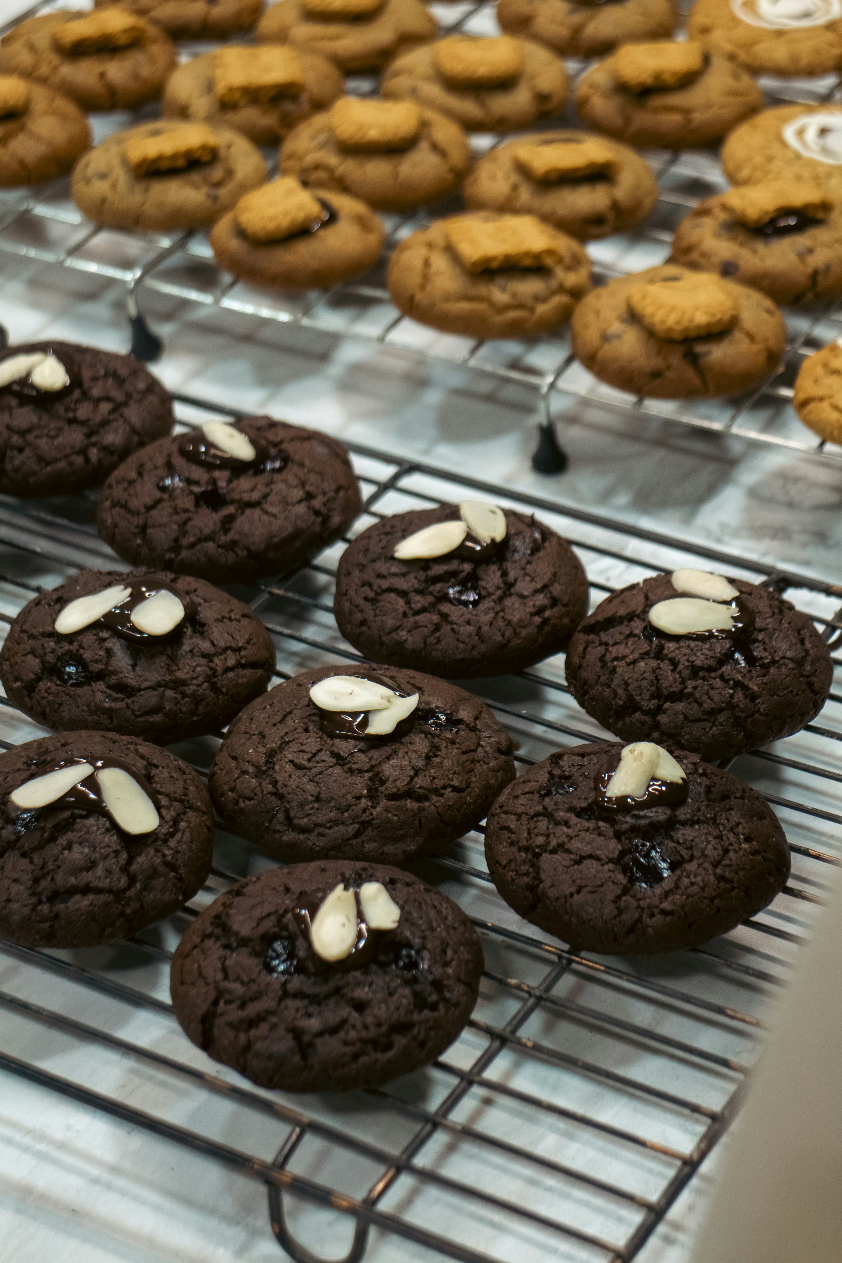 “I highlighted the fresh batch of chocolate cookies cooling with almond toppings for a rustic feel.” | Chocolate cookies with almond slices on cooling rack