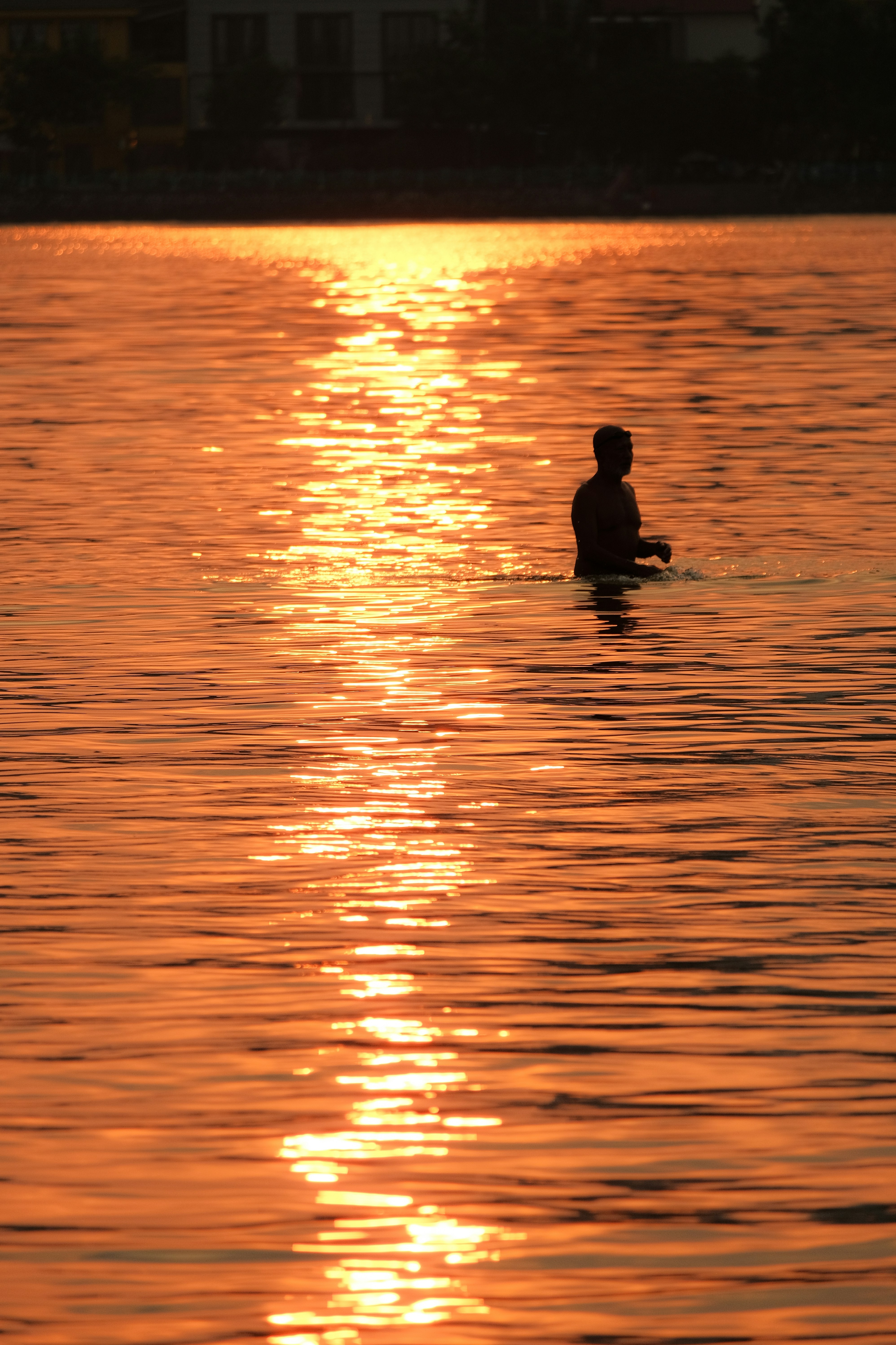 Silhouette of a person in water at sunset