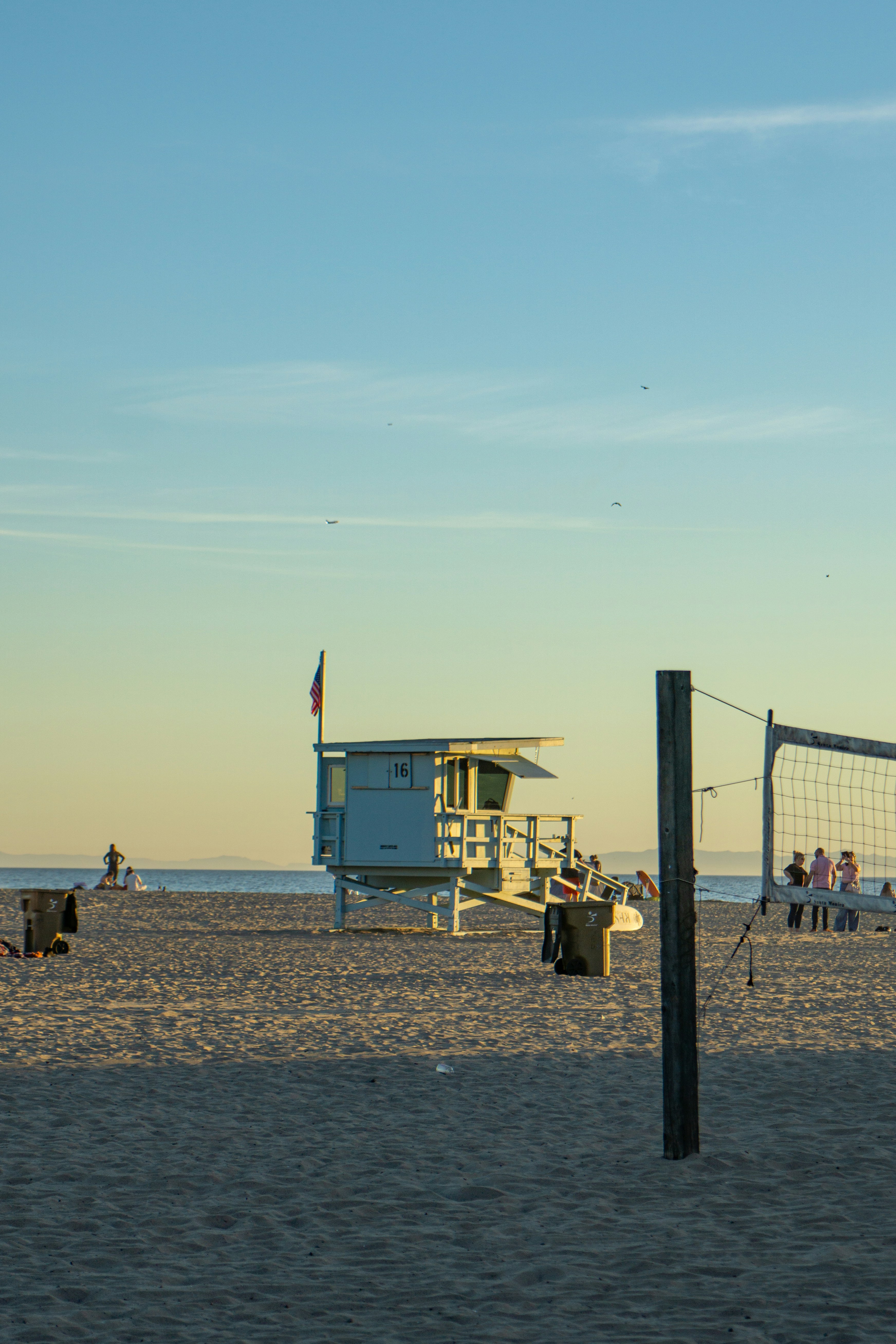 Lifeguard tower and volleyball net on a sandy beach.
