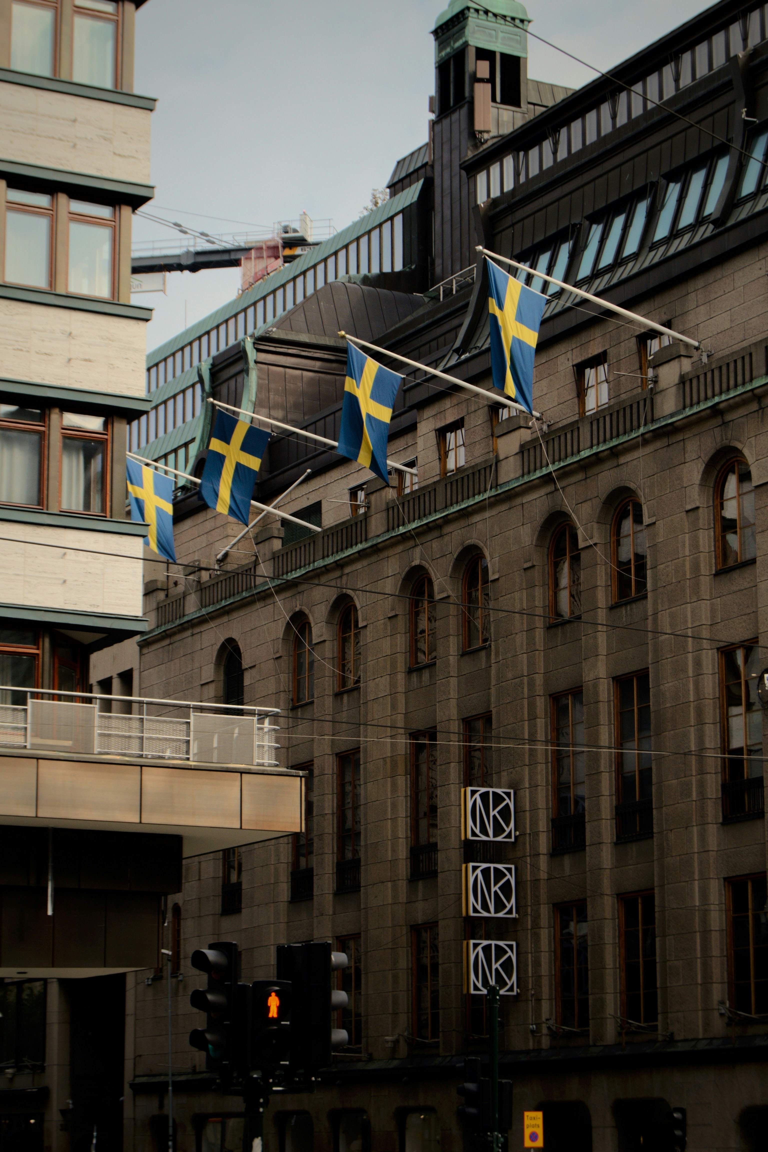Several swedish flags fly outside a building.