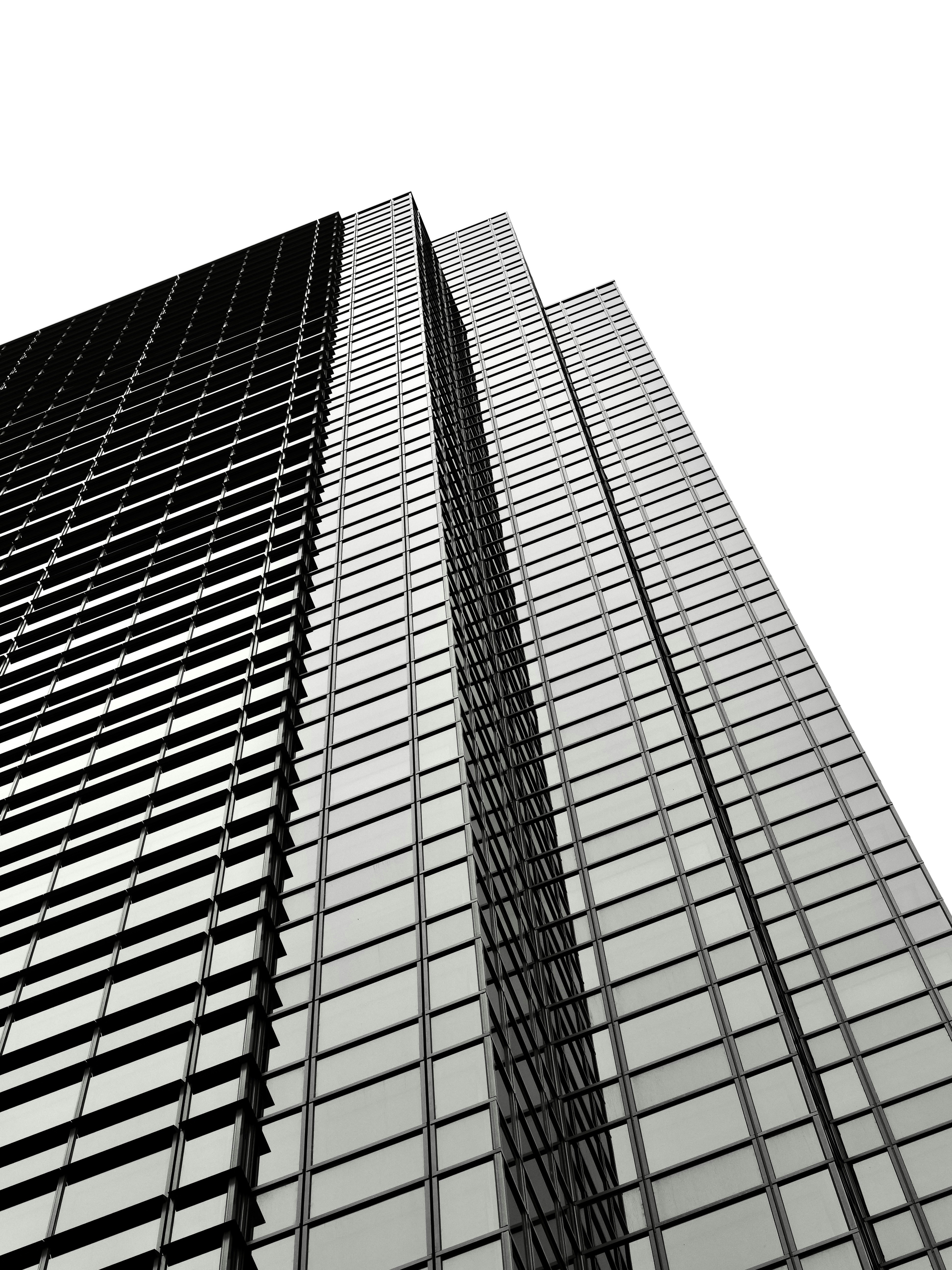 A modern high-rise building with a glass facade | Modern glass skyscraper against a white background