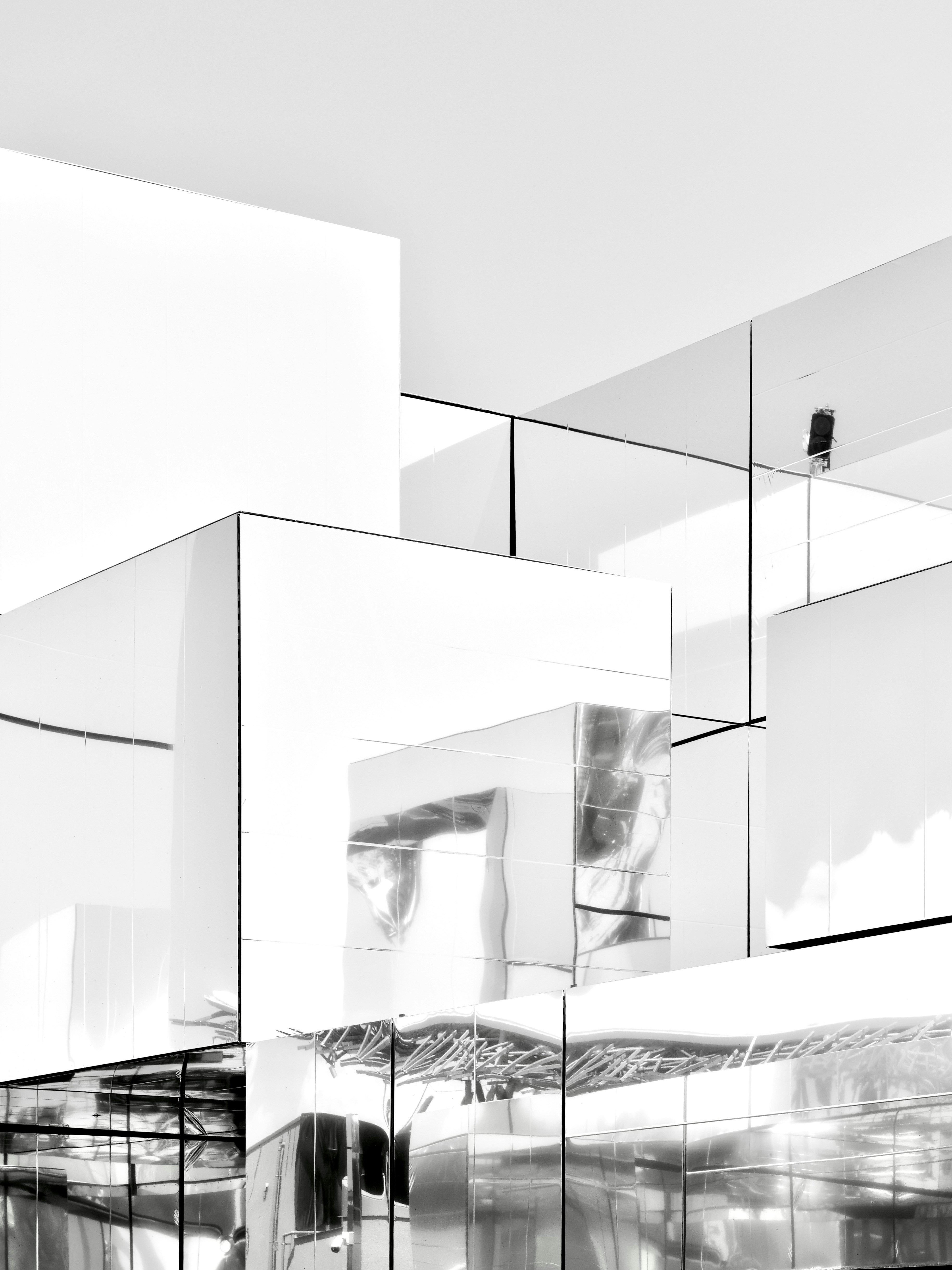 Abstract composition of mirrored surfaces creating intricate reflections and geometric patterns.