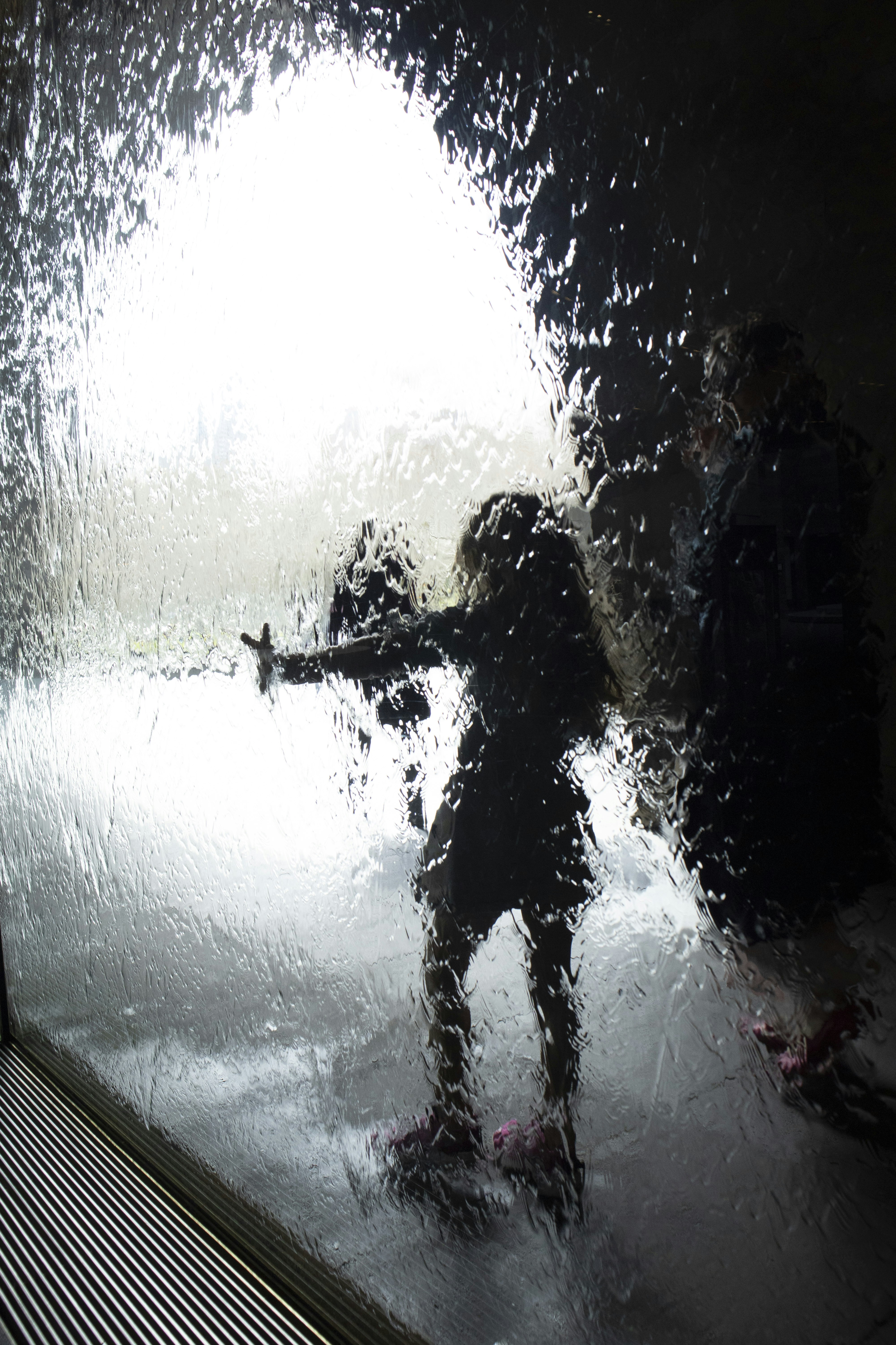 Frosted Glass Silhouettes: Quiet Figures Beyond a Textured Barrier