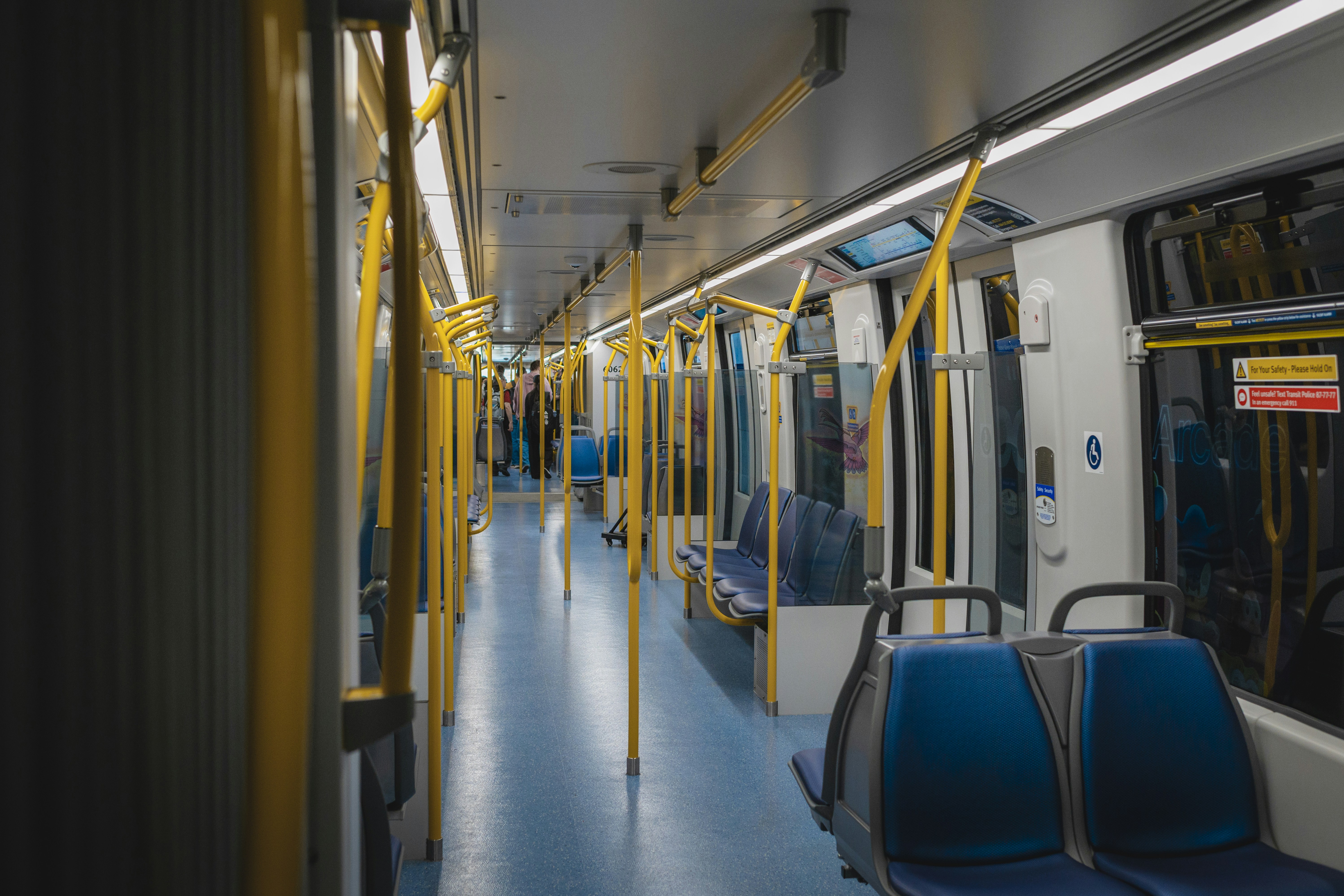 Interior of Translink's brand new Mark V SkyTrain | Empty train interior with blue seats and yellow poles
