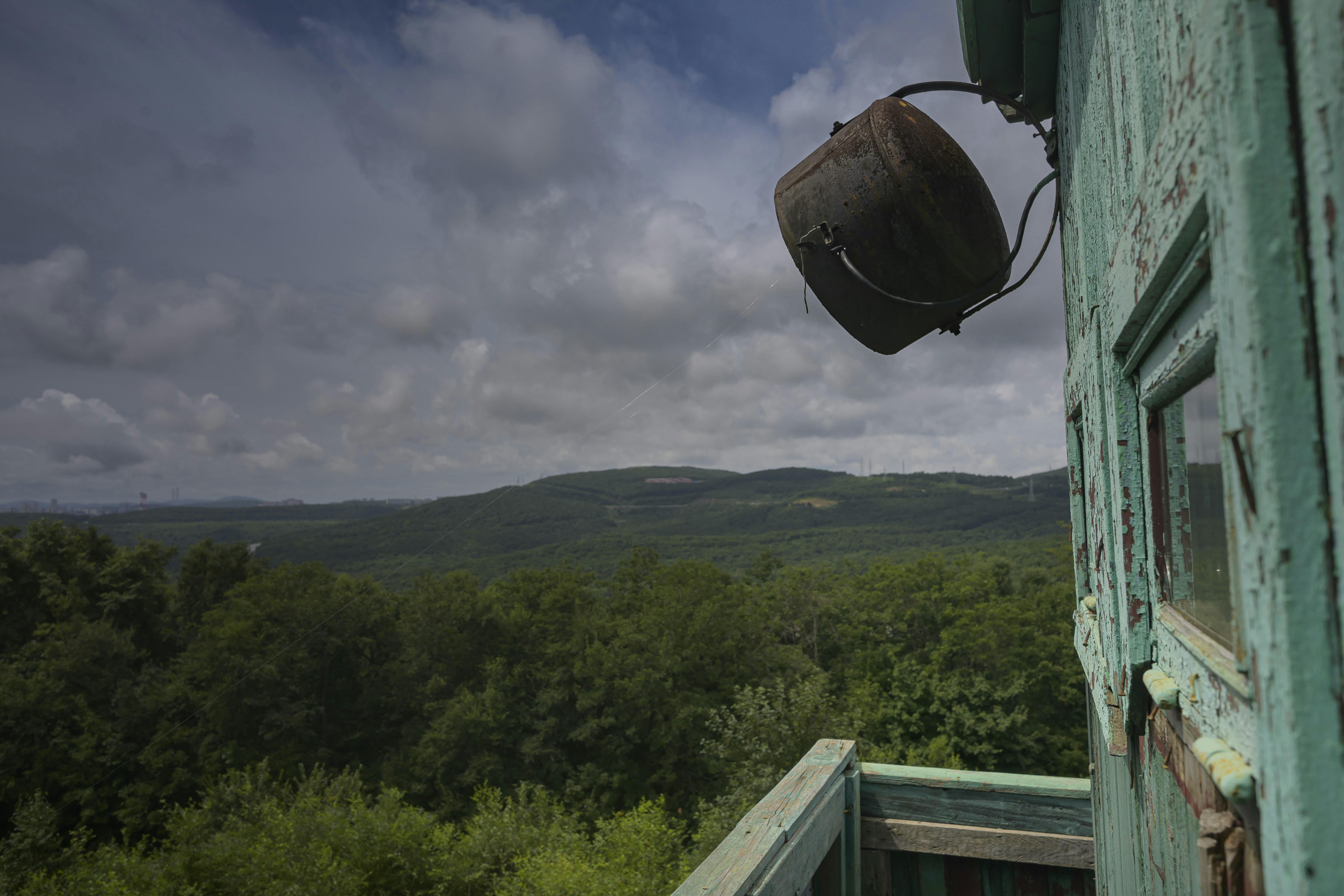 The old watchtower at the entrance to the military area. | Old bucket hanging from a weathered teal building.