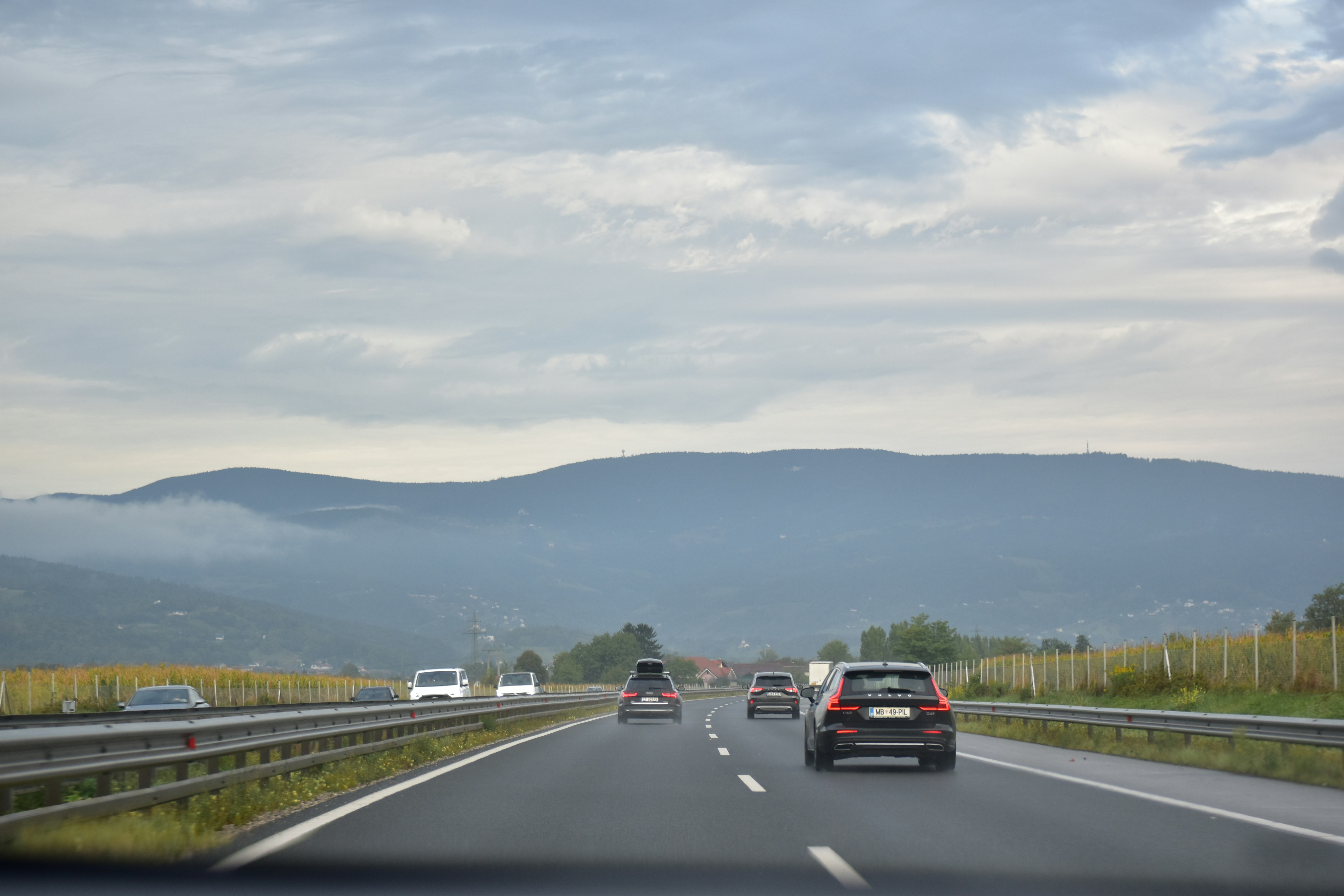 Cars driving on a highway with mountains in background