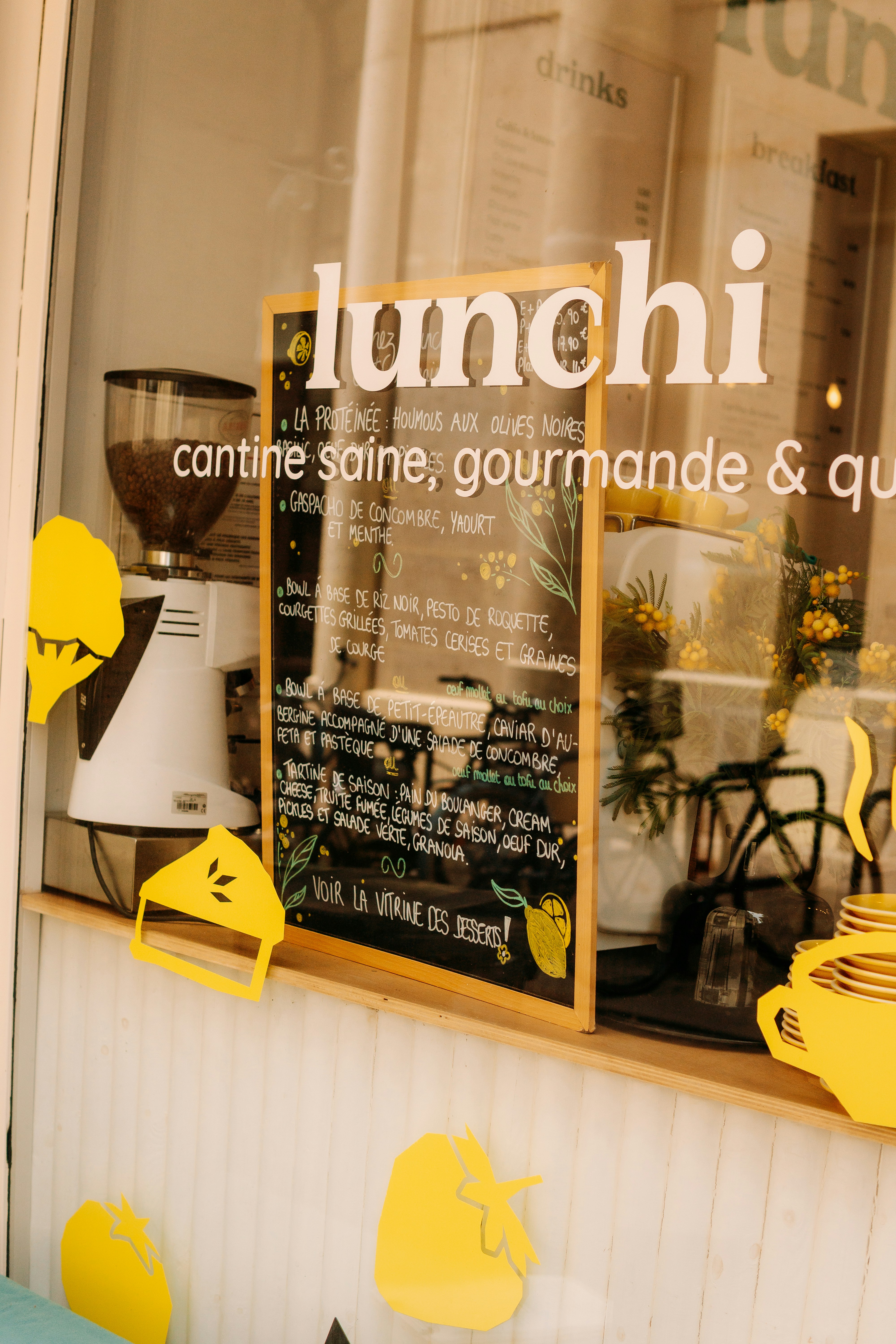 A cafe window displays a lunch menu with yellow decorations. photo ...