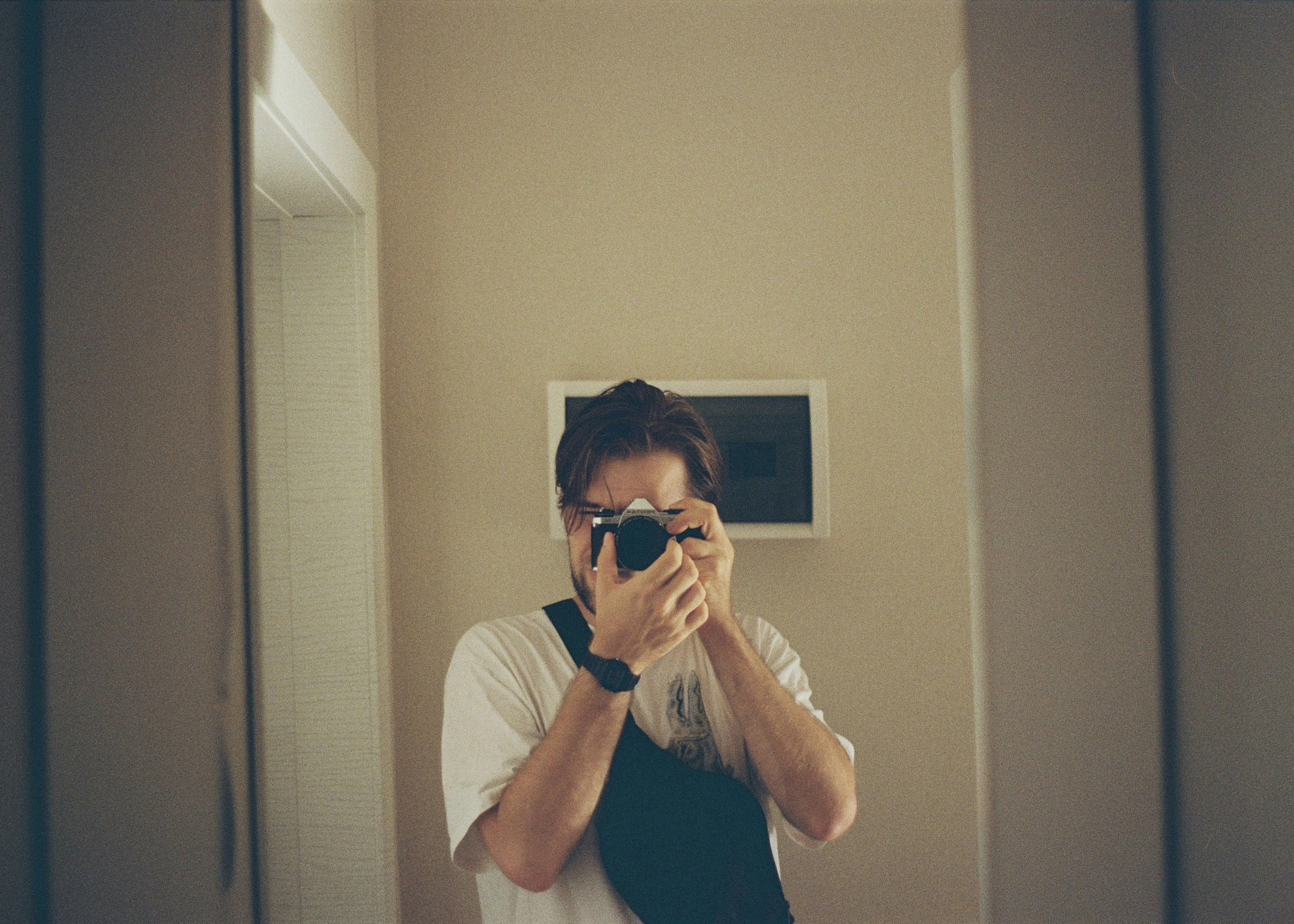 Man taking a selfie with a vintage camera